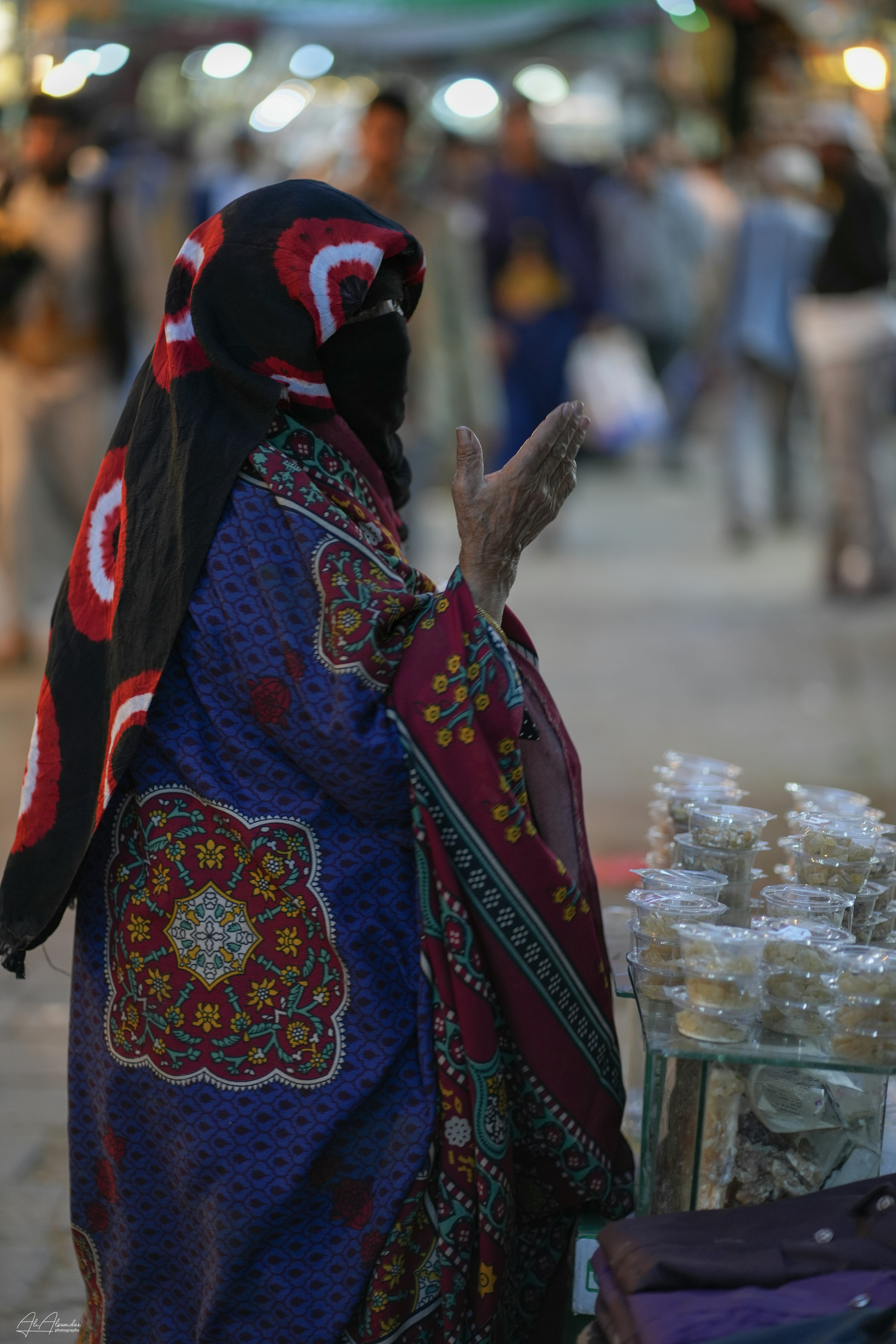 Colorful Veil, Quiet Gesture: A Moment at the Market