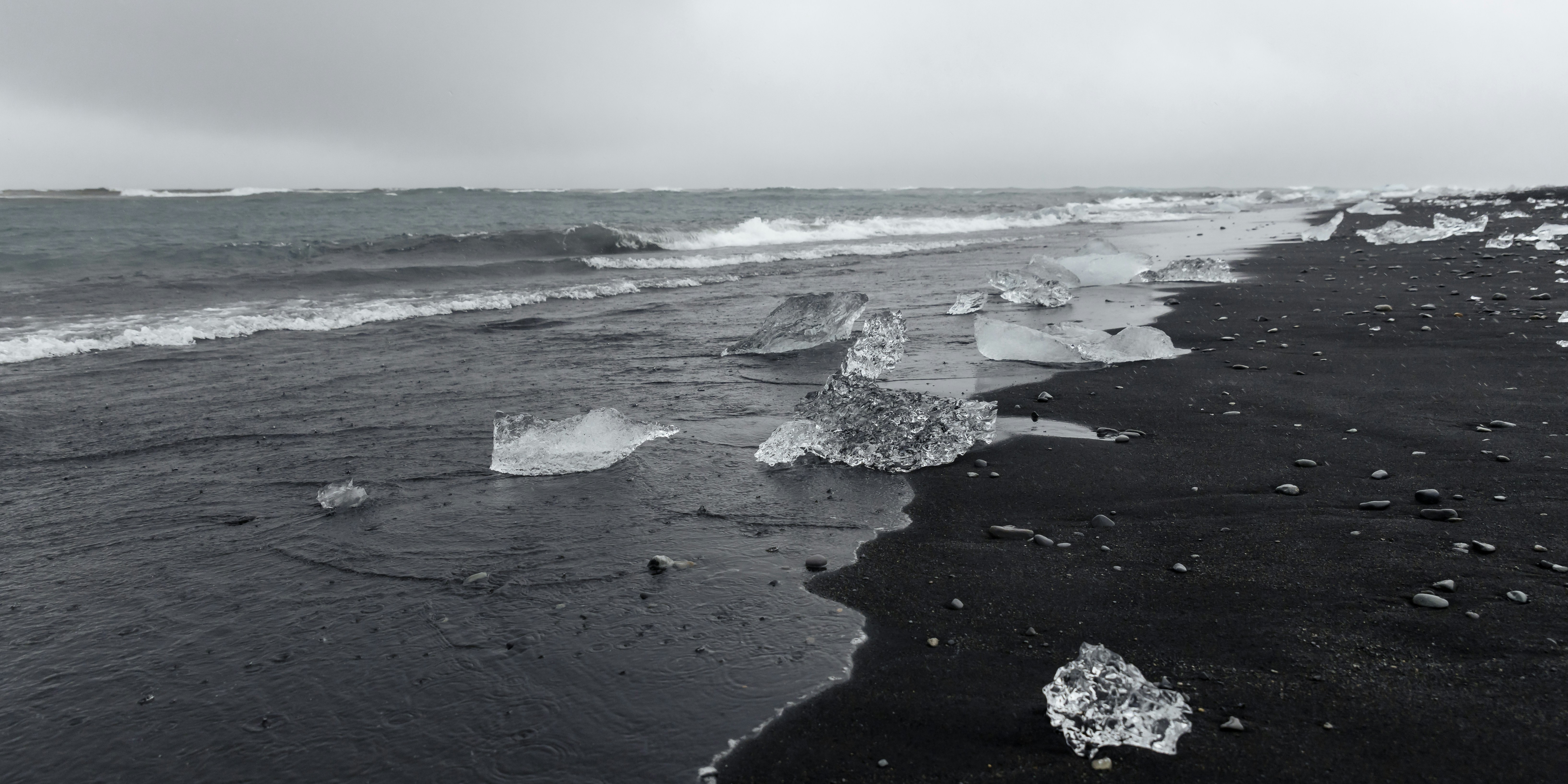 A black and white photo of a beach with ice and water photo – Free ...
