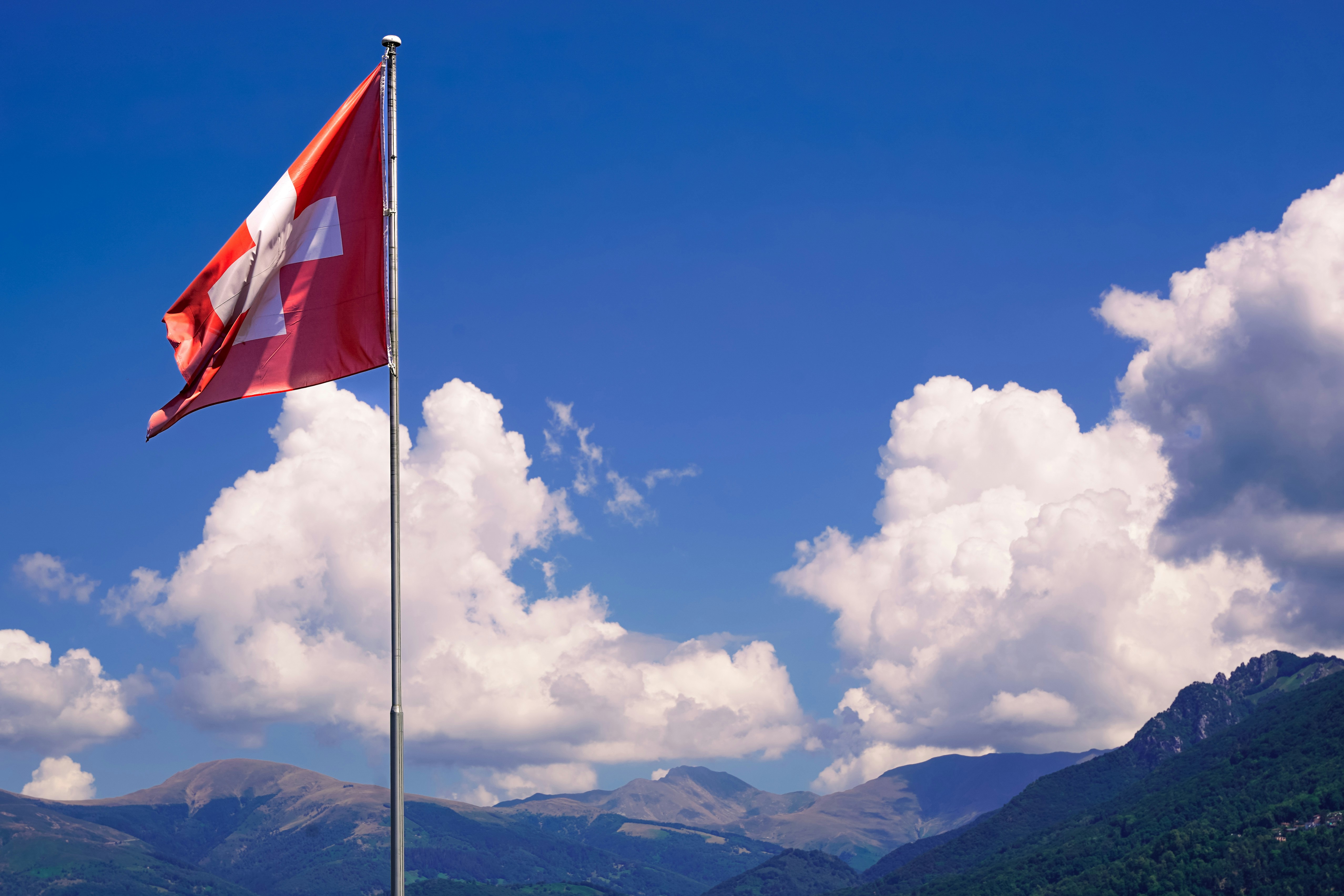 Swiss Flag Pierces the Alpine Horizon under a Cobalt Sky