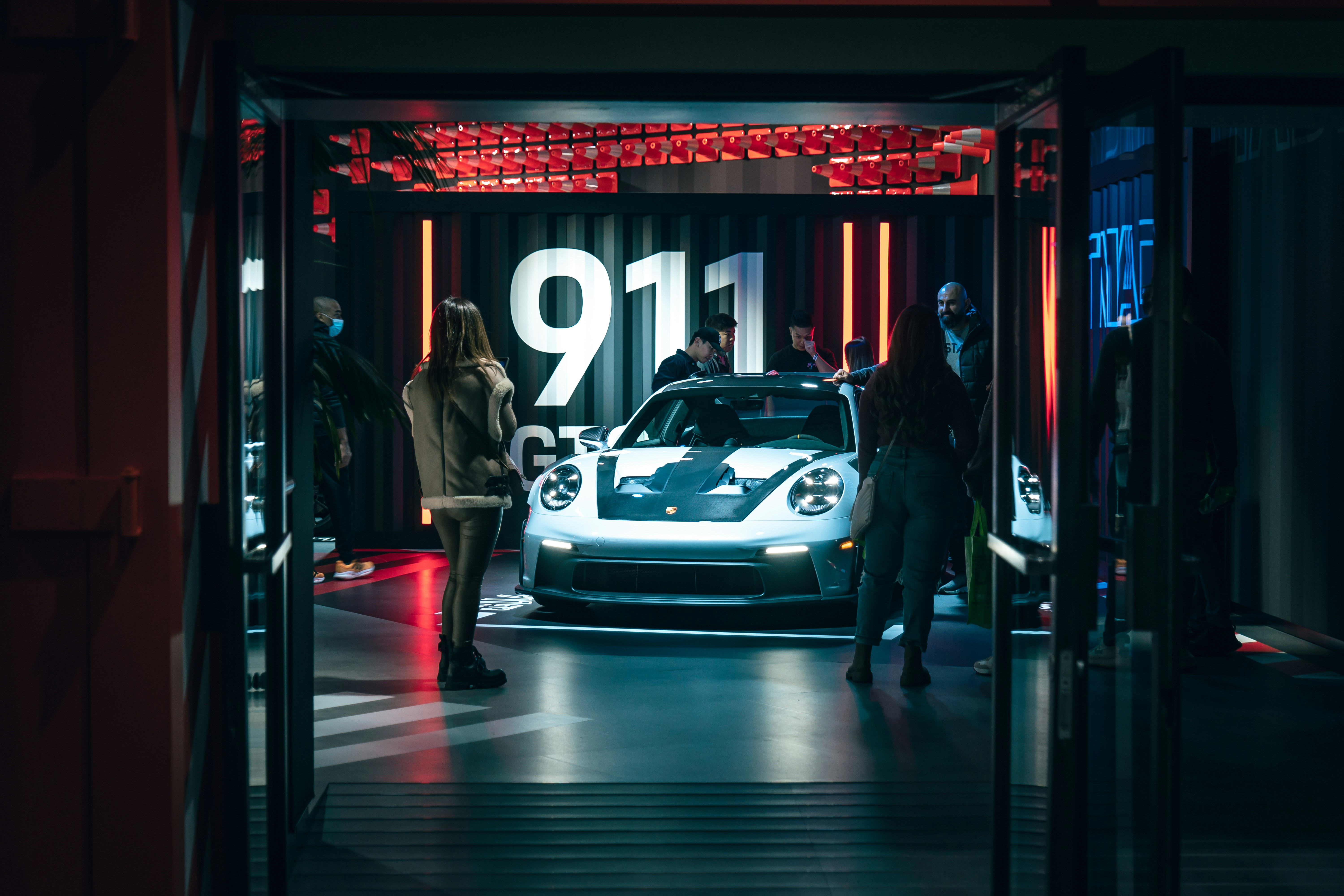 Neon-Accented Porsche 911 GT Under Red-Lit Showroom Lighting