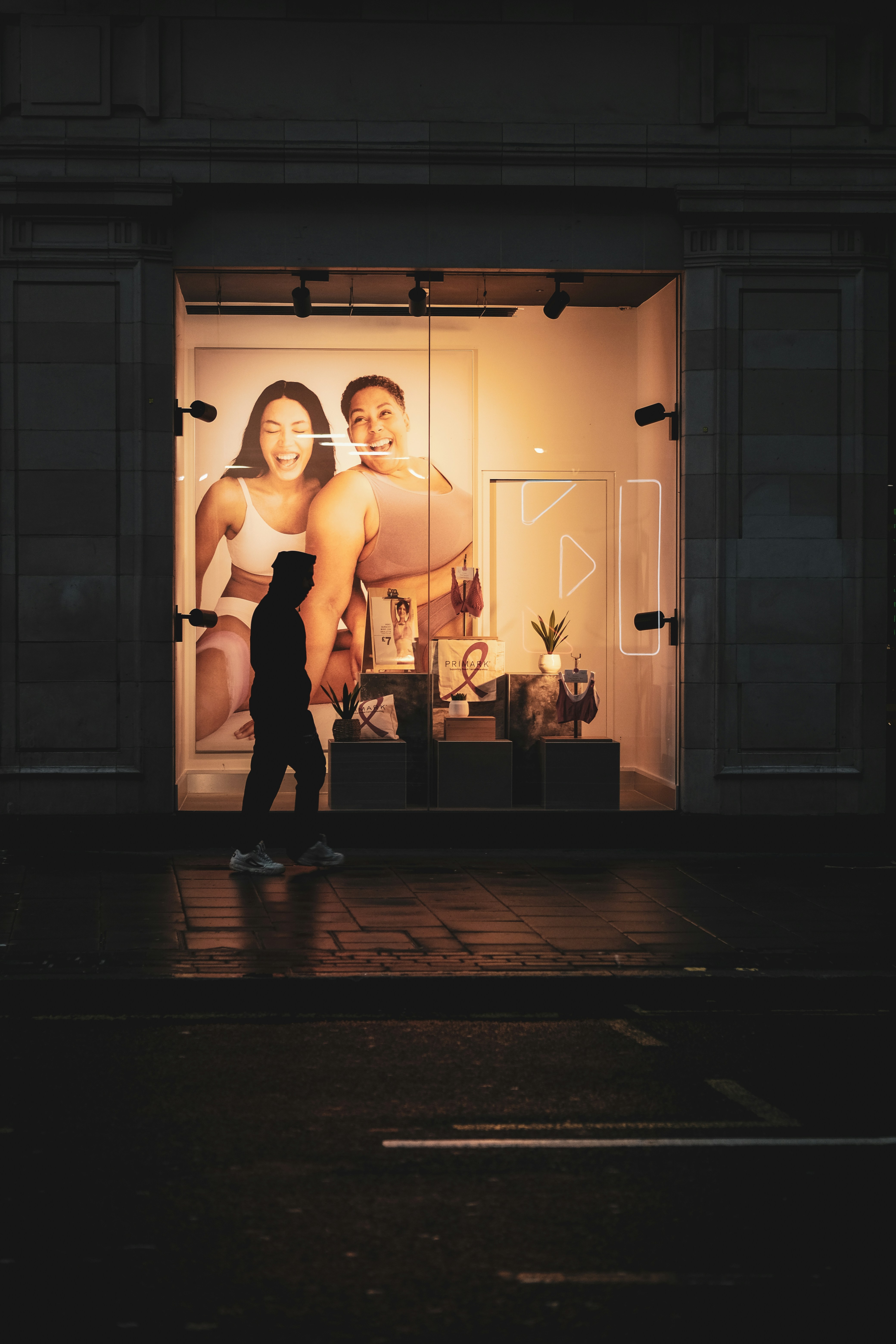 Shadow Crossing the Glow: Night Walk Past a Fashion Window
