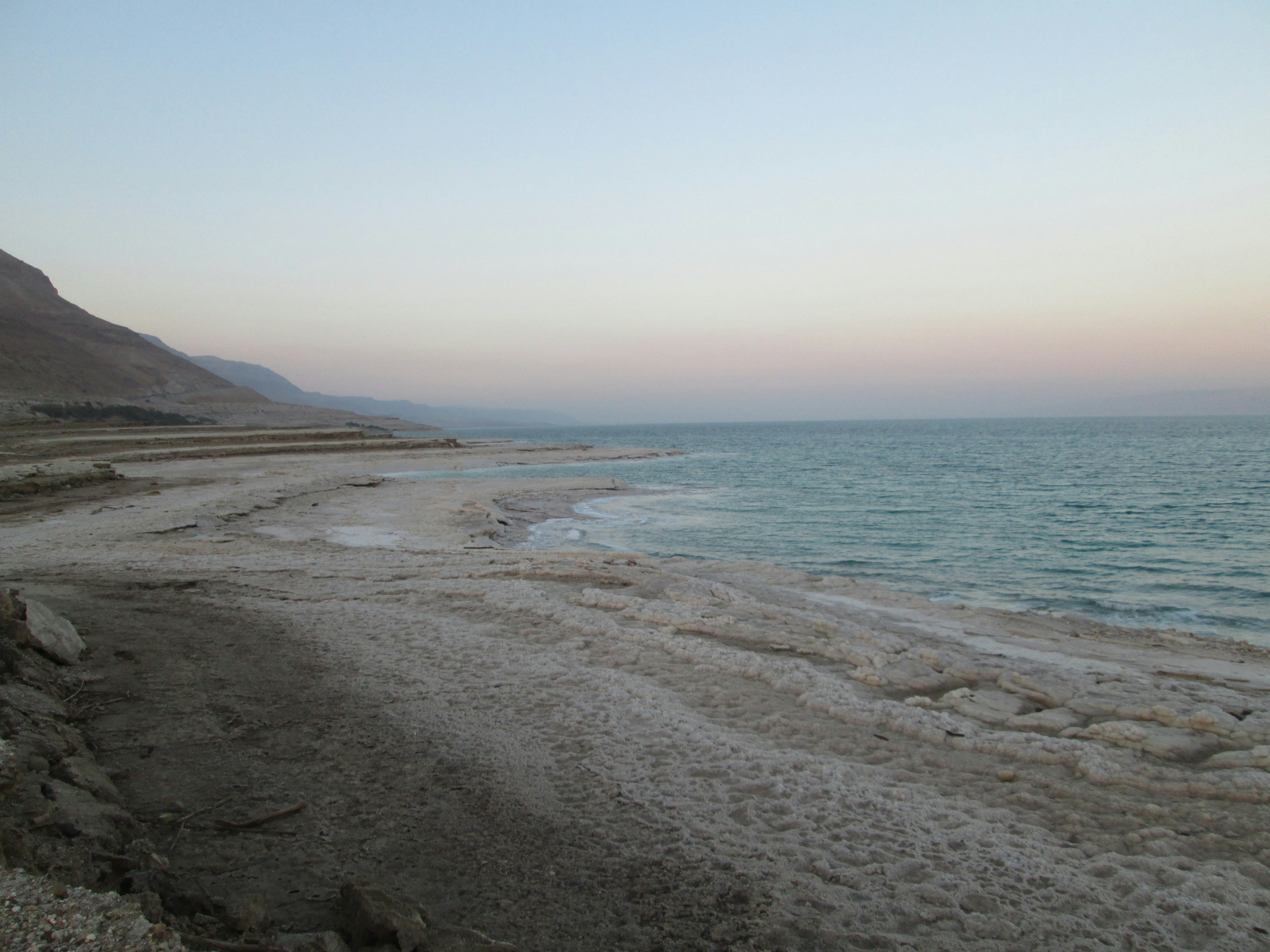 Salted shoreline at dusk: terraced flats meet calm horizon