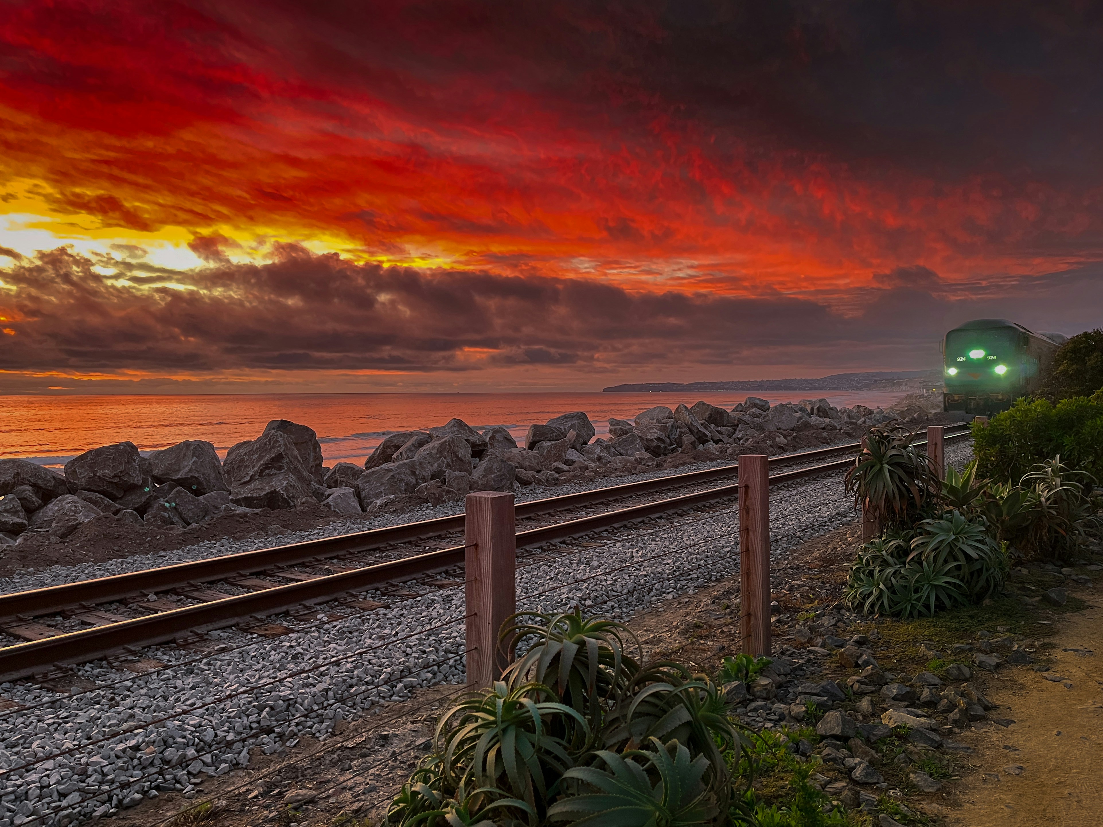 Crimson Horizon Over Coastal Rails at Dusk