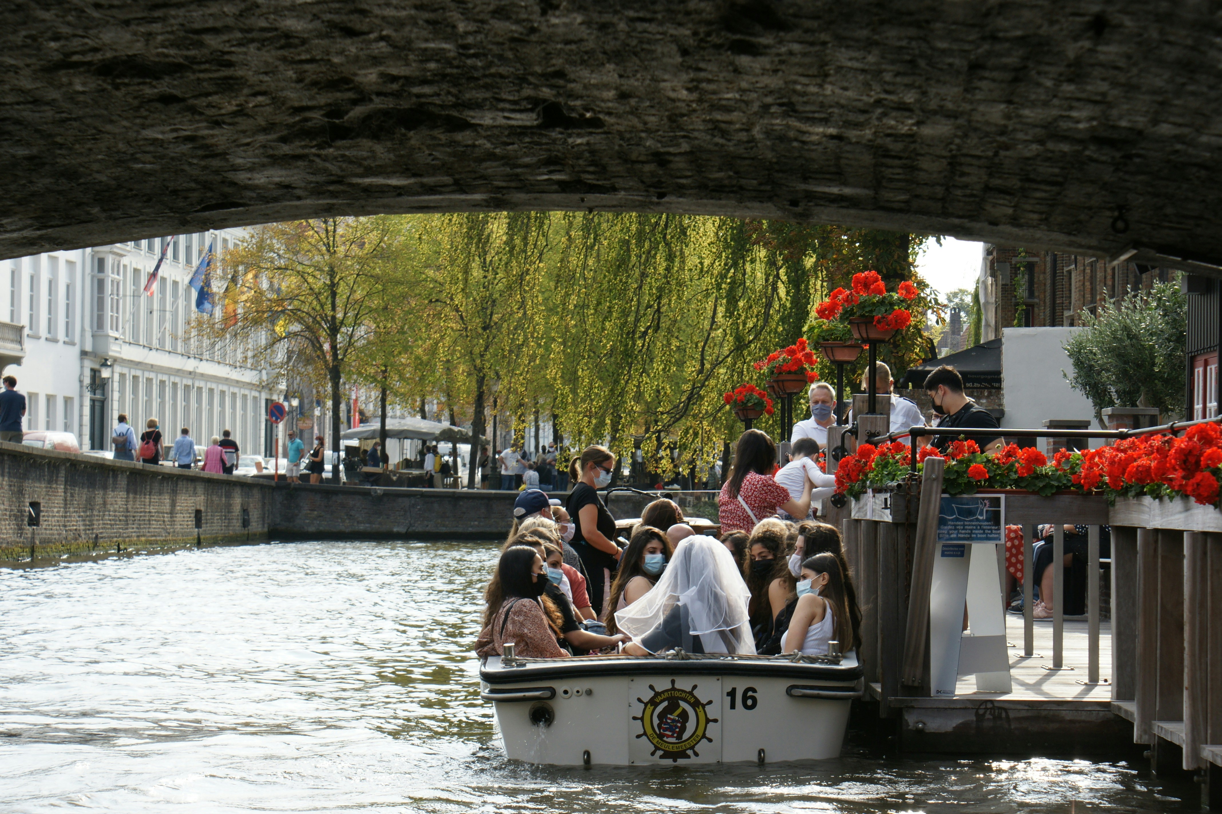 A group of people on a boat under a bridge photo – Free Canal Image on ...