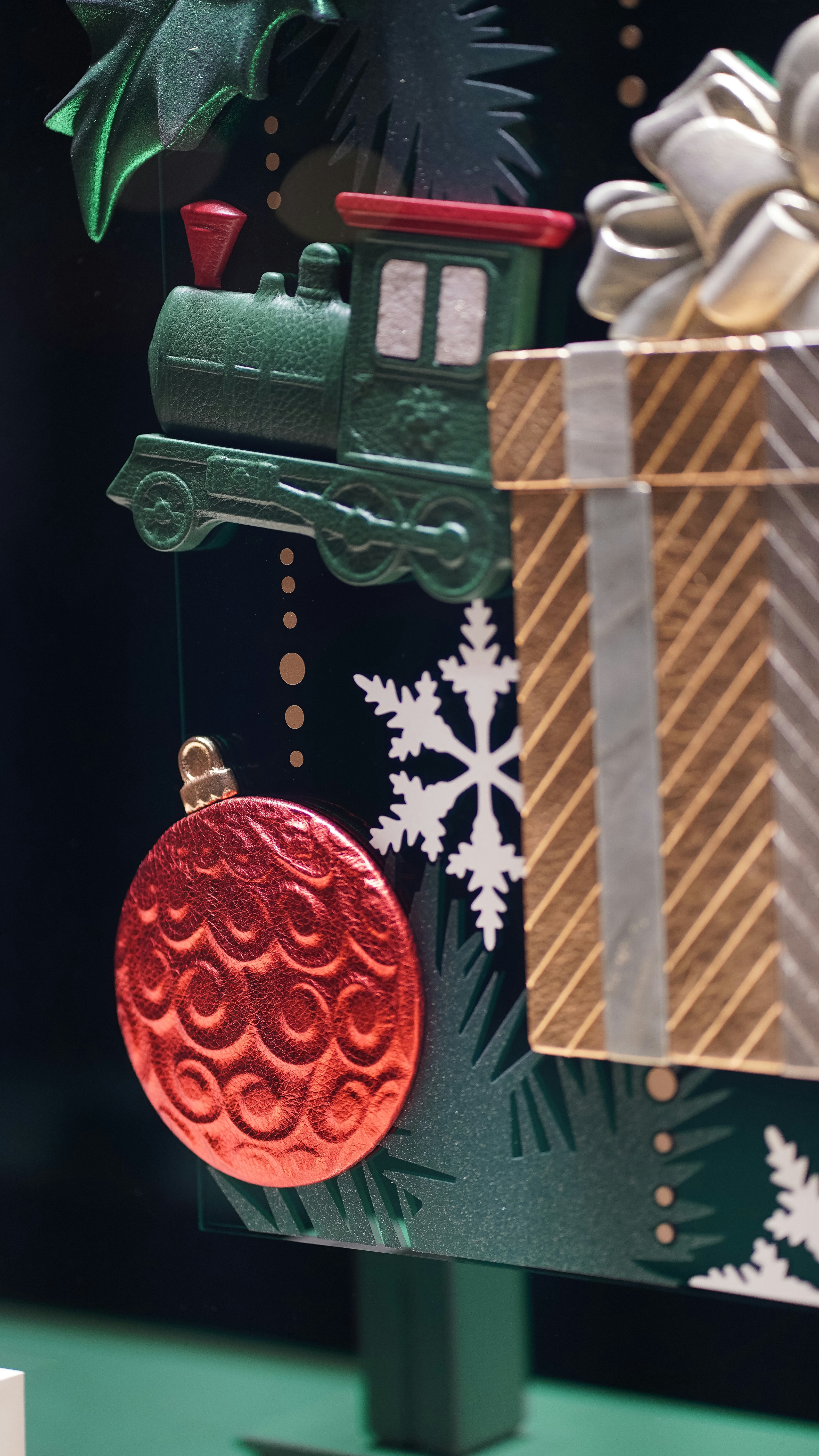 Green Steam Engine Anchors a Festive Display of Gifts and Snowflakes