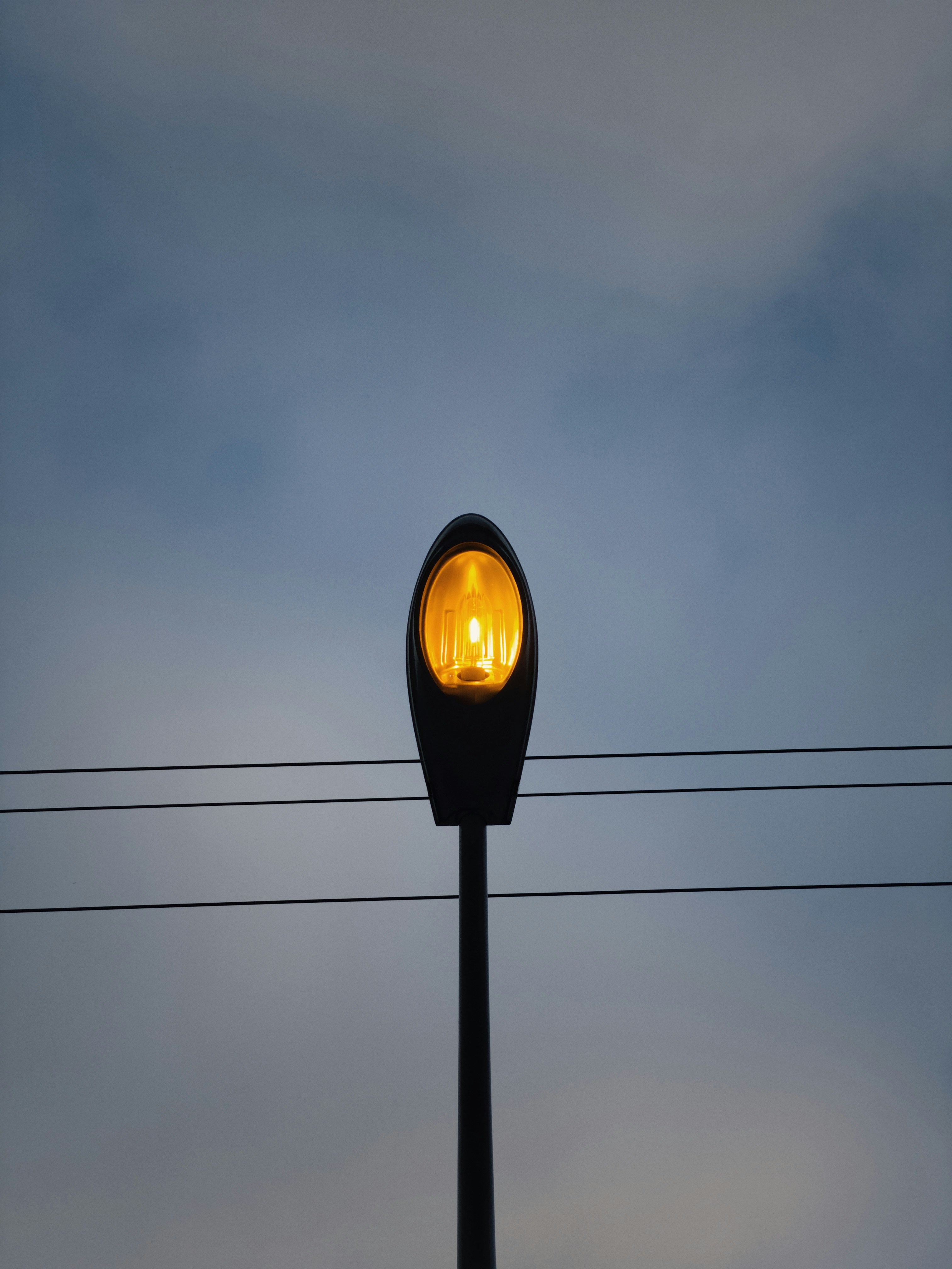 Street lamp glow against a quiet evening sky