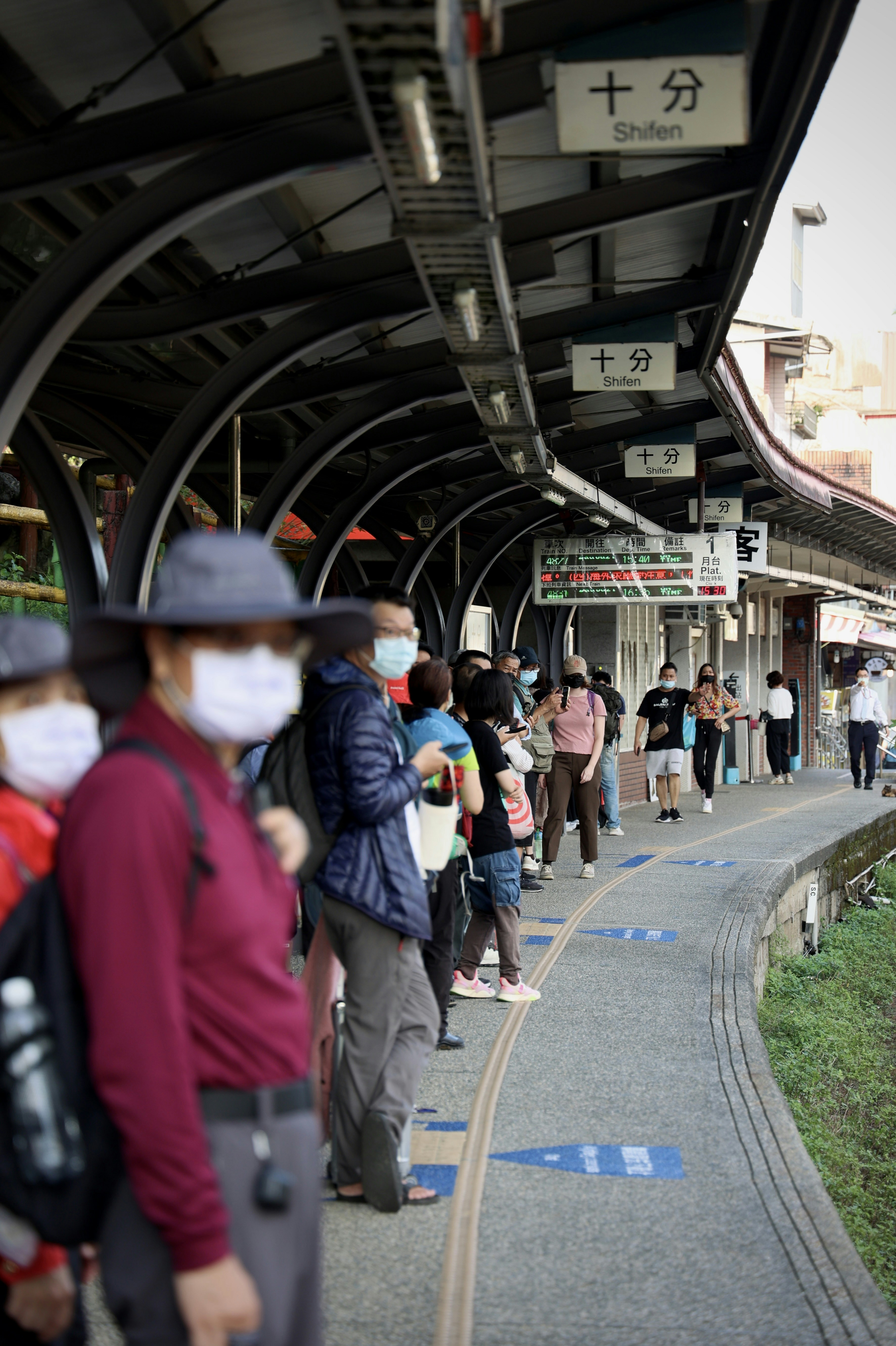 Shifen Platform Under Arched Canopies: A Quiet Queue in Masks
