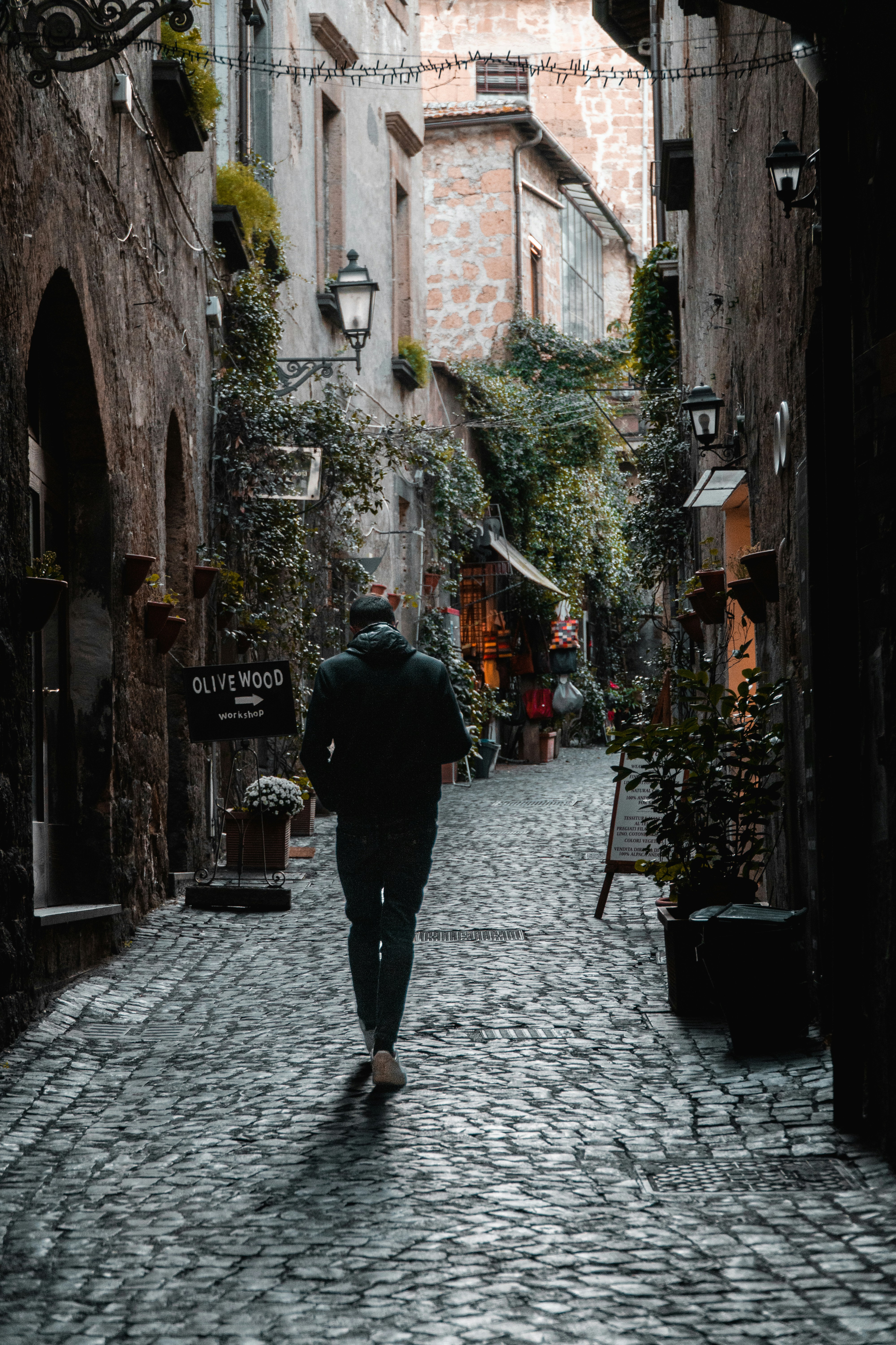 A man walking down a narrow street photo – Free Orvieto Image on Unsplash