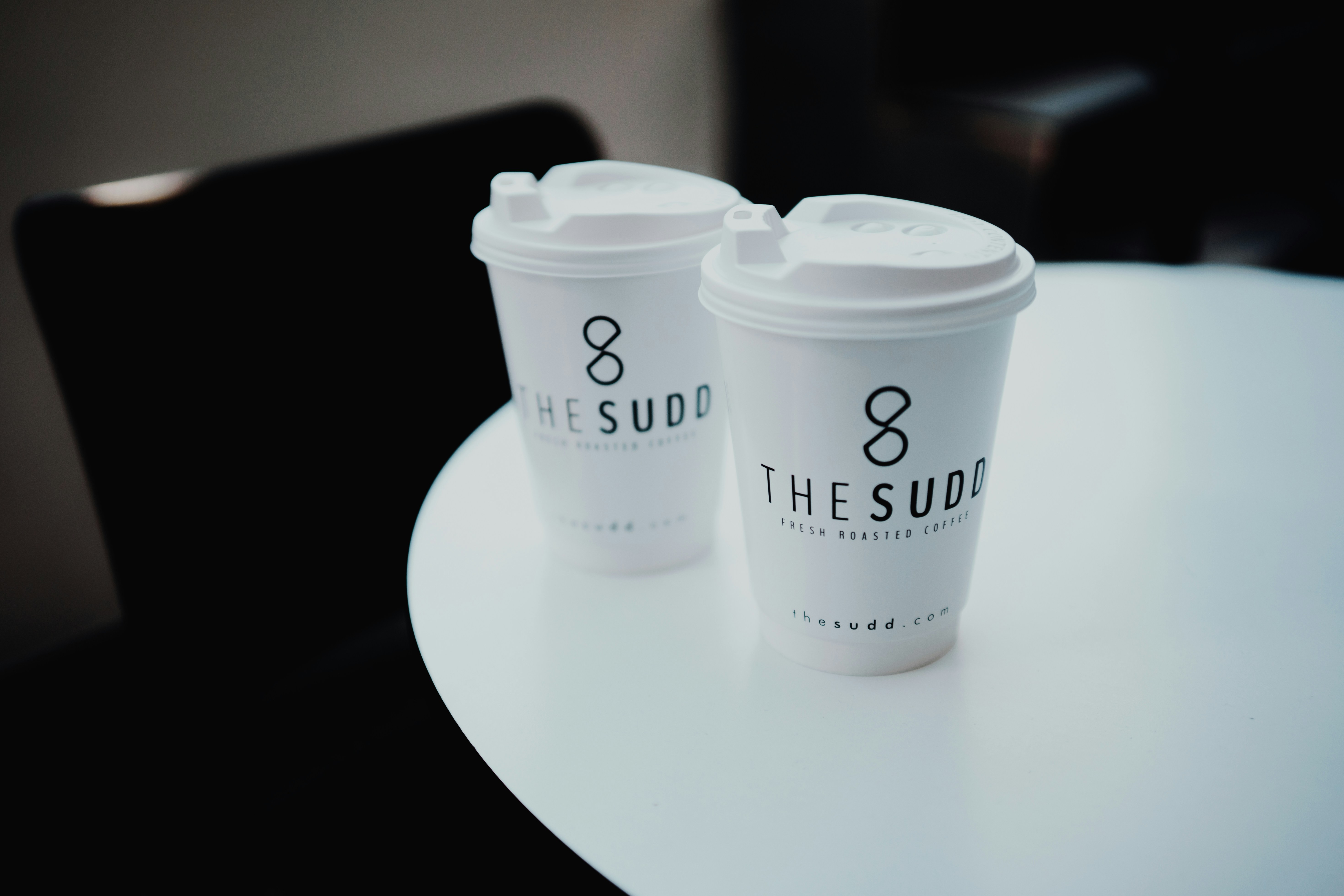 Twin White Takeaway Cups on a Quiet Café Round Table