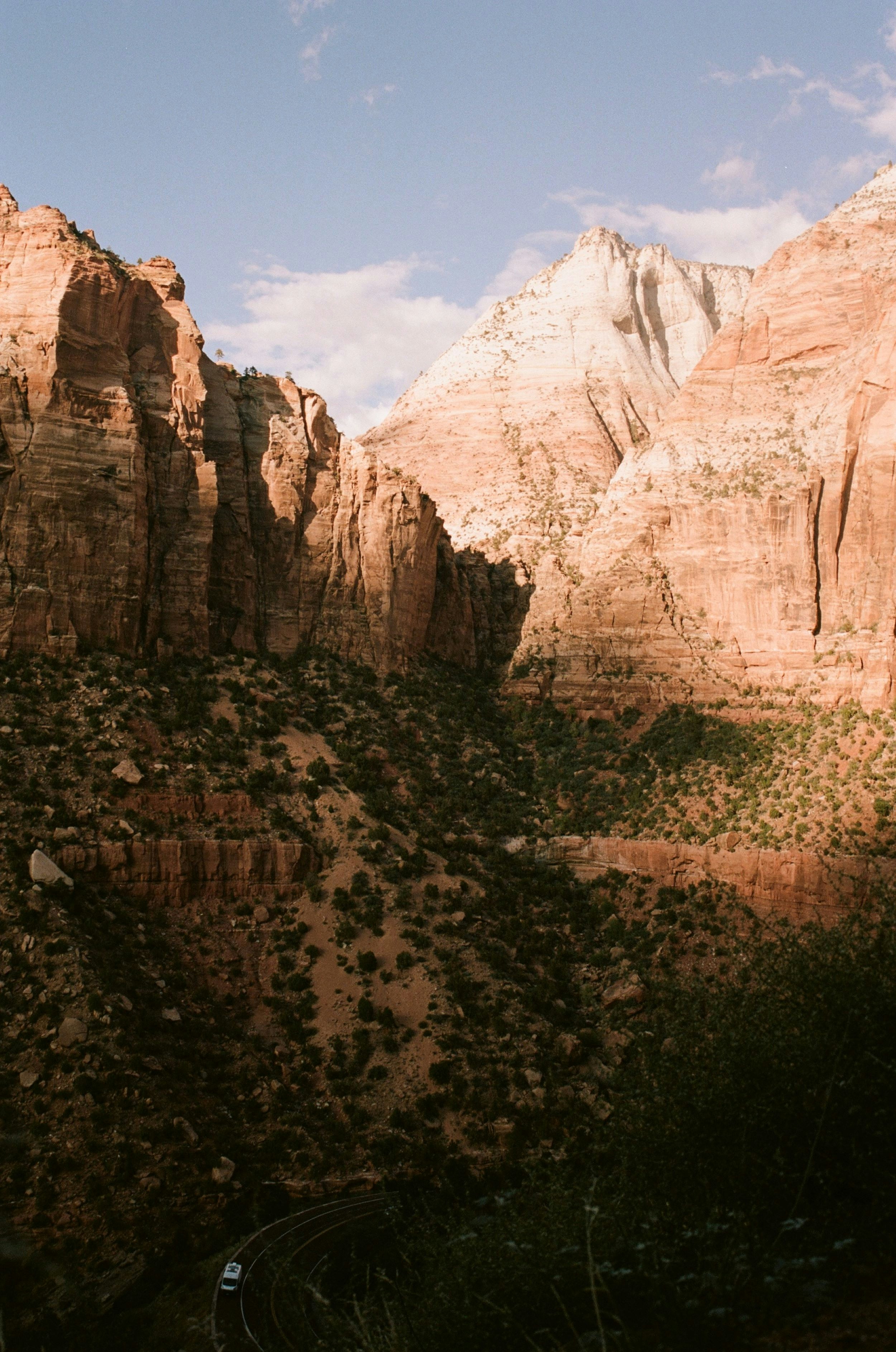 A rocky mountain with trees with Zion National Park in the background ...