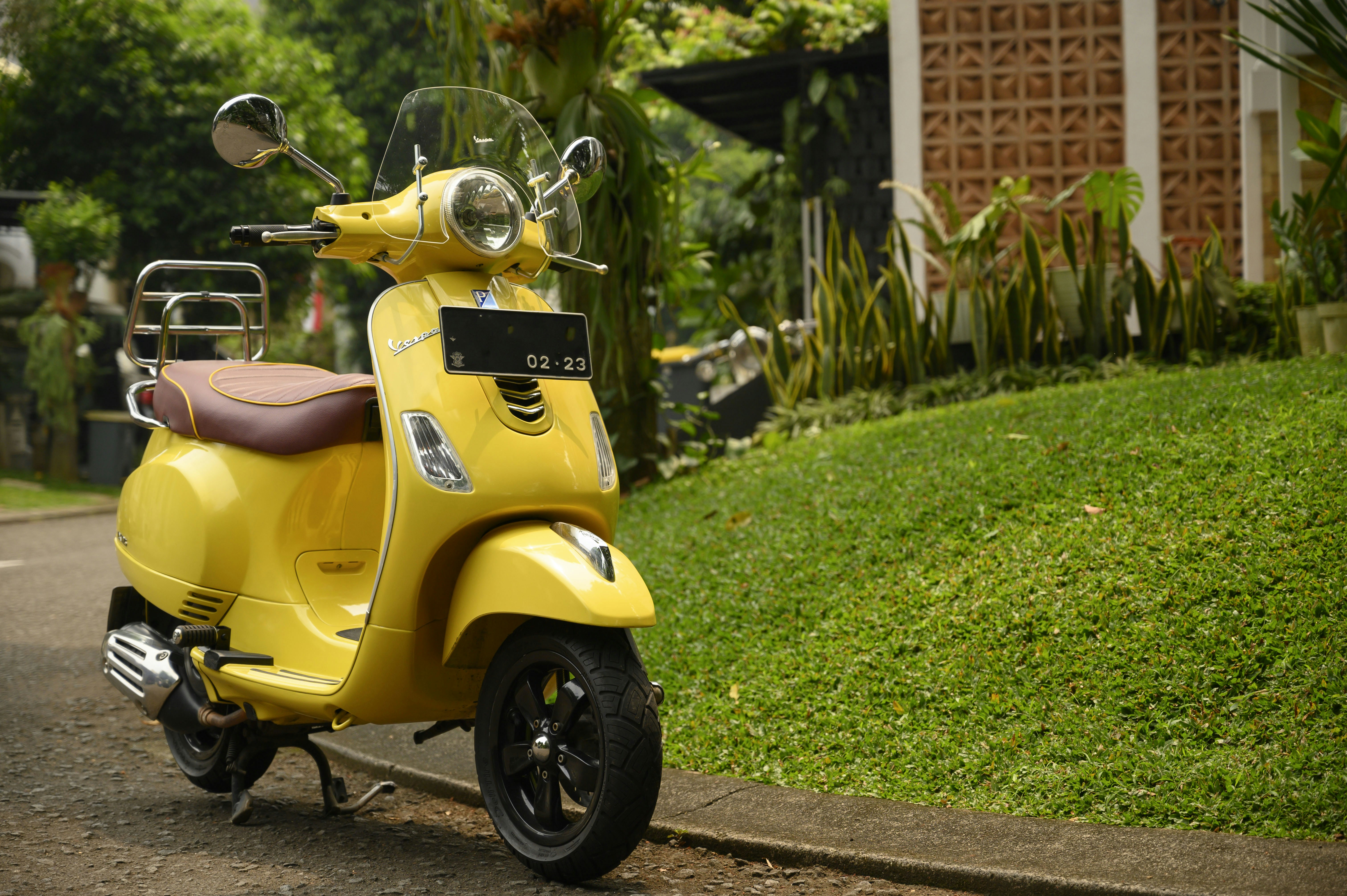 Sunlit Yellow Scooter Resting by the Garden Path
