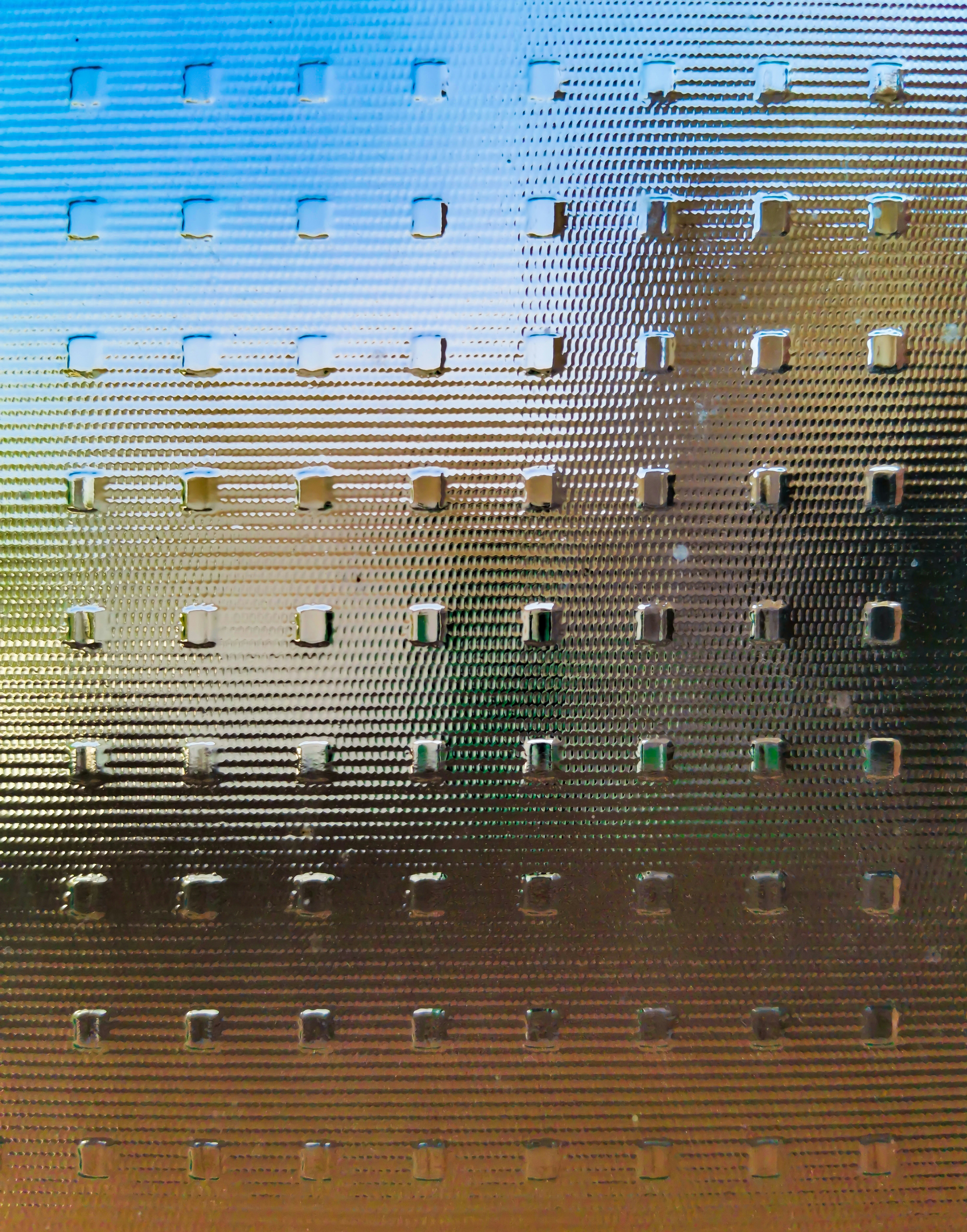 Color-Shifted Grid: A Macro Portrait of a Dimpled Metal Surface