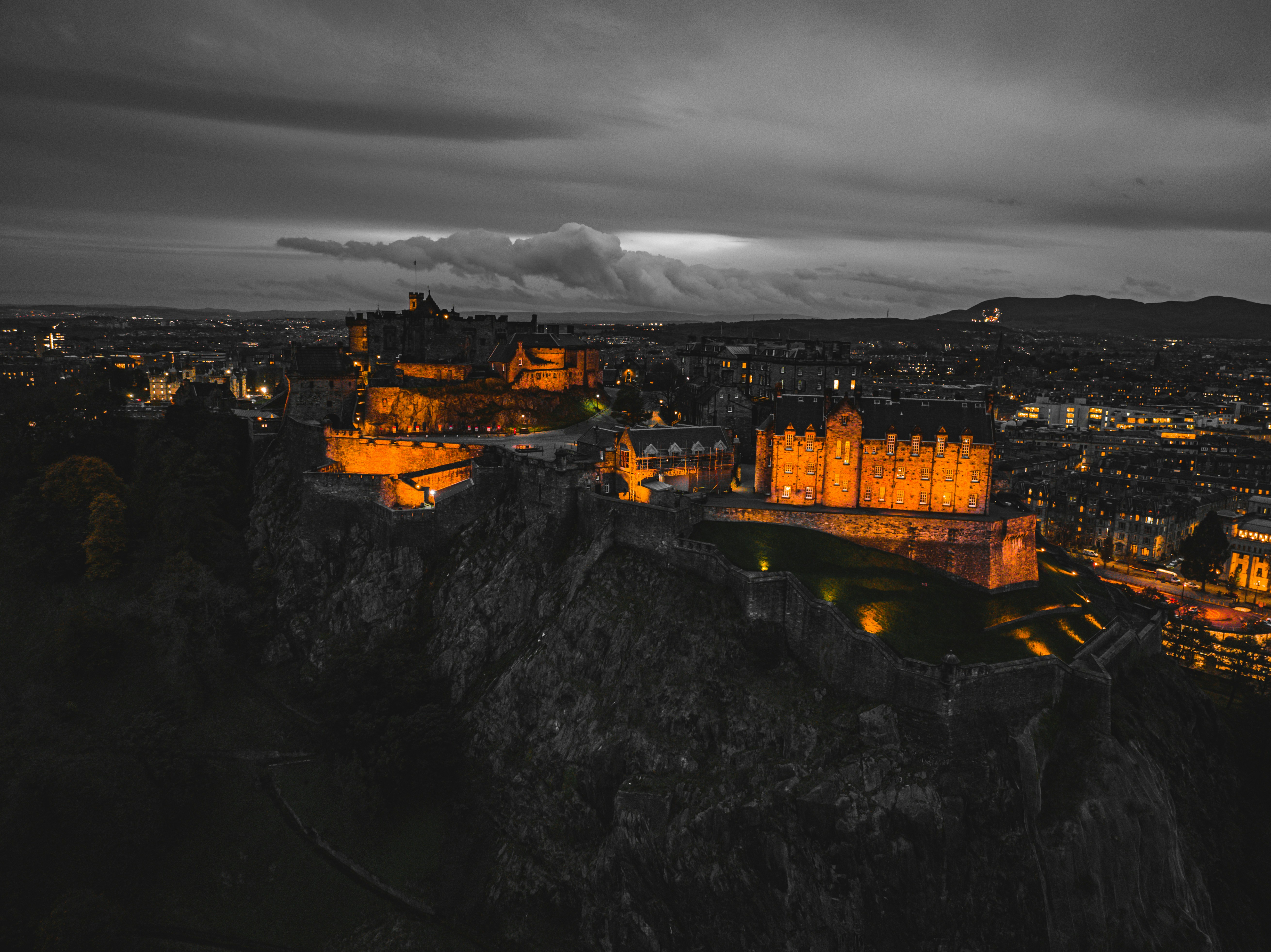 Luminous Castle Complex Looms Over a Darkened City at Dusk