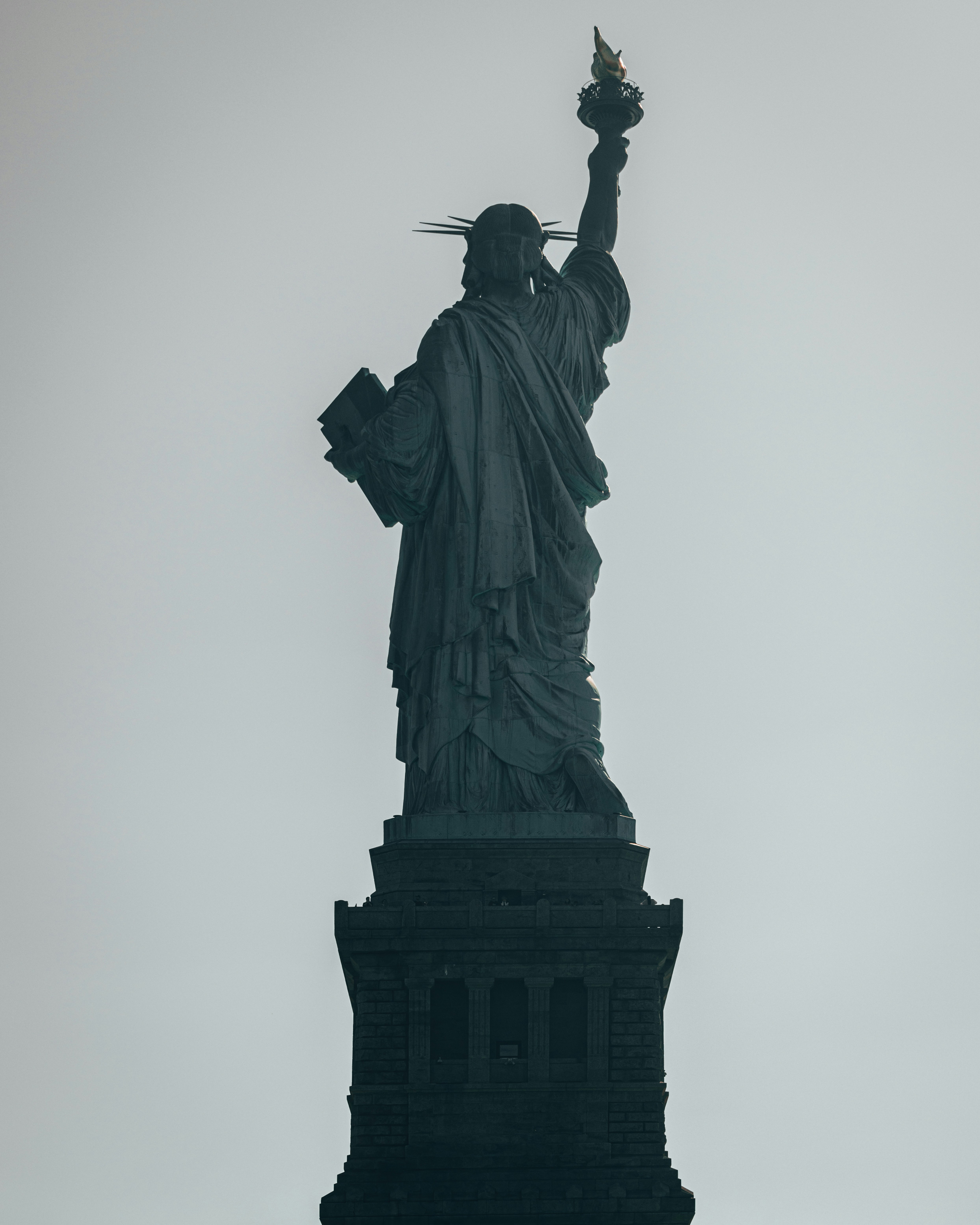 The Torch Against Gloom: Liberty’s Silhouette at Dusk