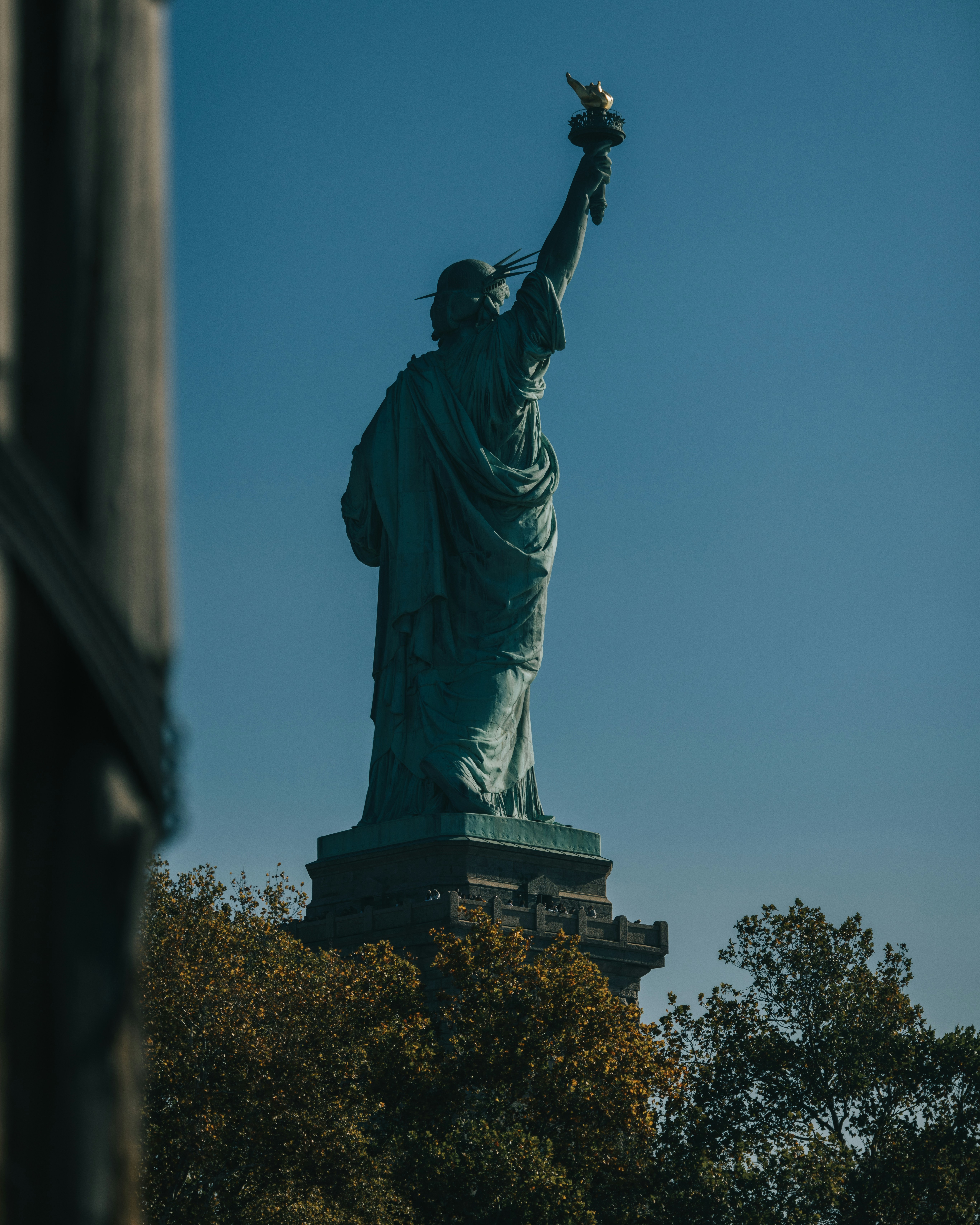 Cerulean Sky, Raised Torch: The Statue of Liberty Reaching Toward Daylight