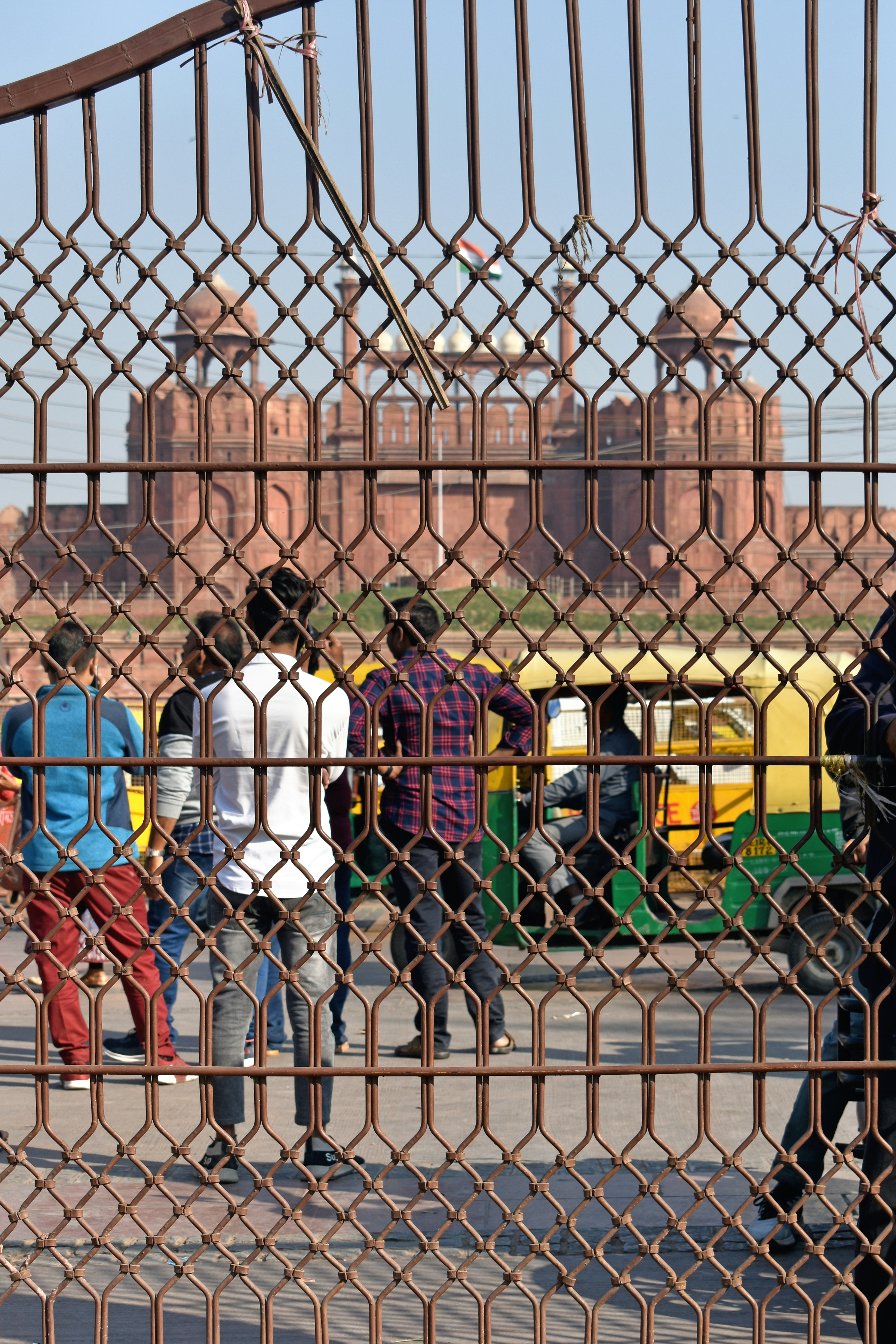 The iconic Red Fort or Lal Qila—a 17th century historic fort in Old Delhi, India built by the Mughal emperor Shah Jahan, and a UNESCO World Heritage Site—as seen through the iron gate of Chandni Chowk entrance [Photo: November 2022]