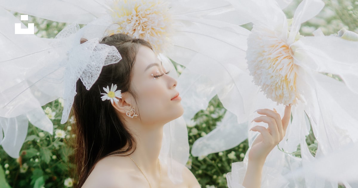 하얀 드레스를 입은 사람이 하얀 드레스를 입고 다른 여자에게 키스하는 모습 사진 Unsplash의 무료 꽃 이미지