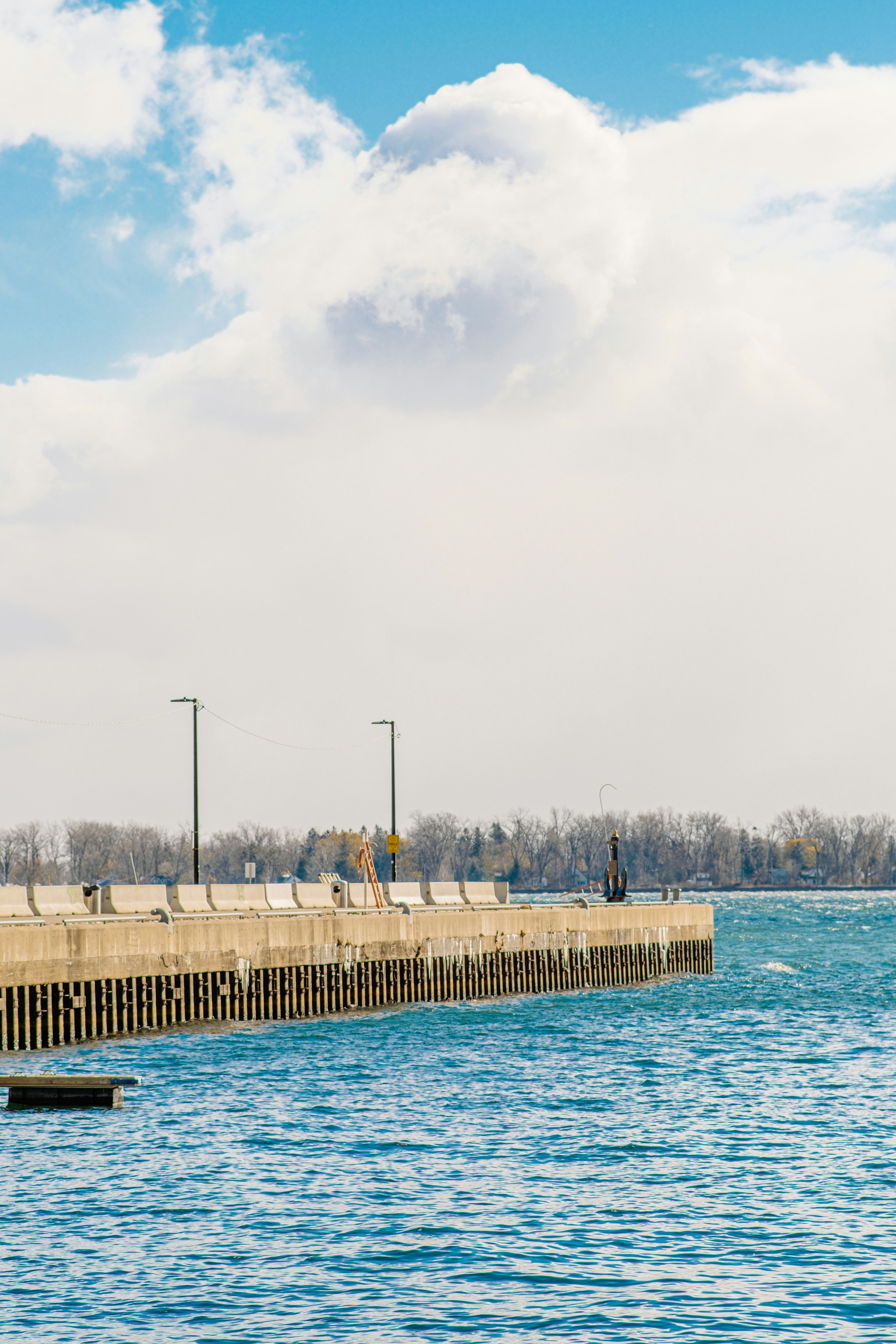 Lone Silhouette on a Concrete Jetty Beneath a Wide Sky