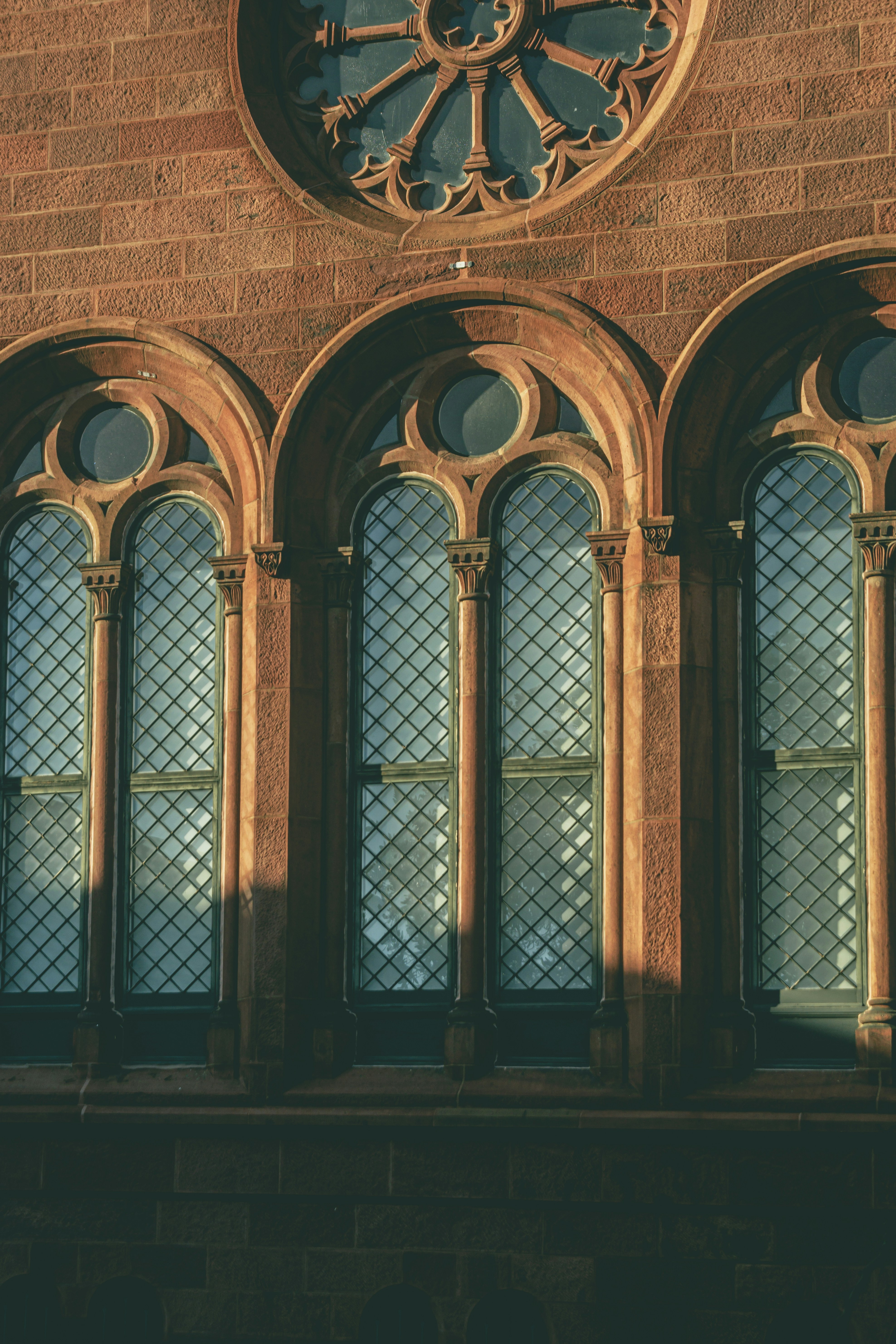 Golden Hour Arches: Warm Light Tracing Gothic Windows Across Weathered Stone