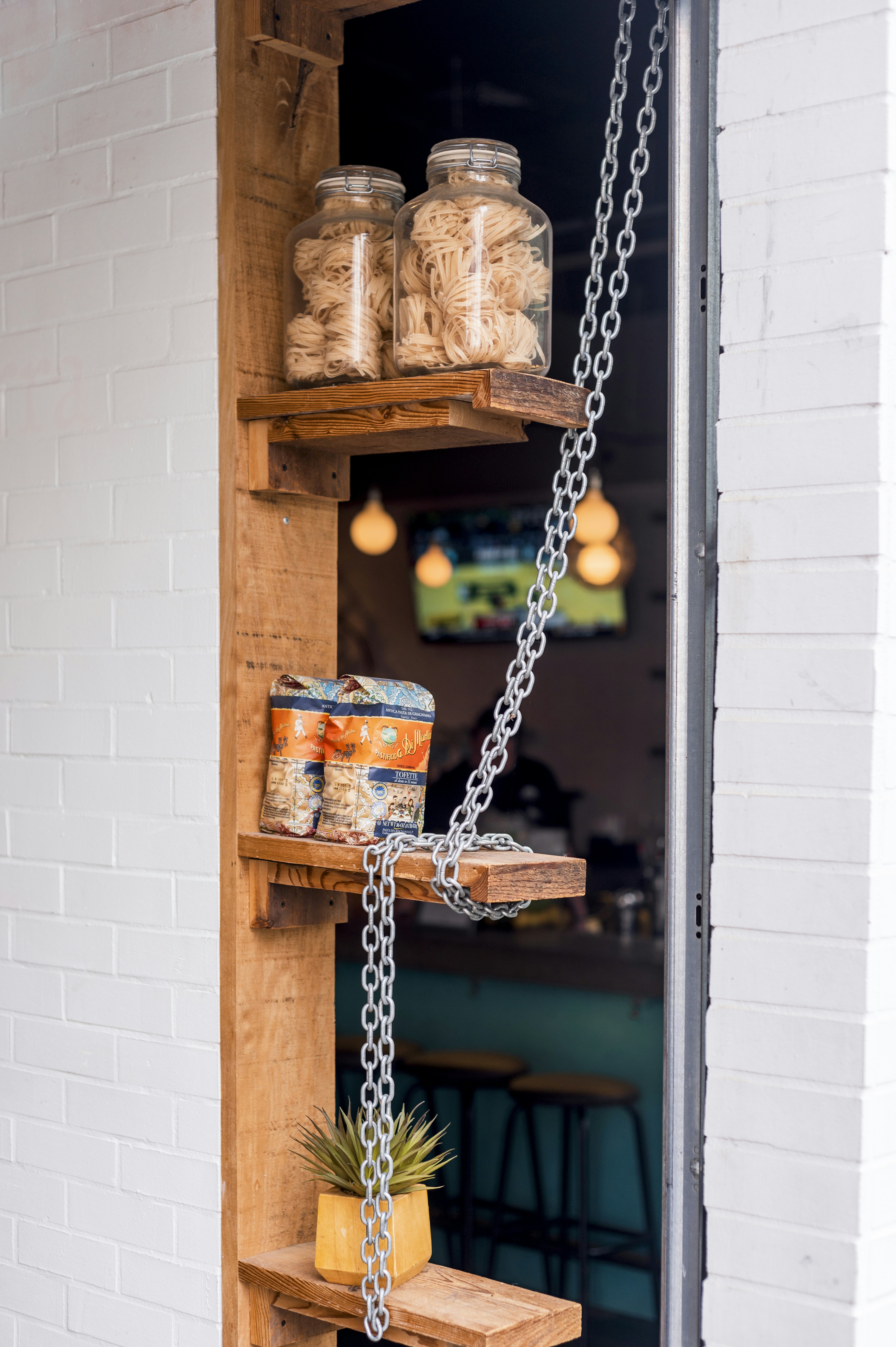 Rustic Ladder Shelf with Jars Framing a Café Entrance