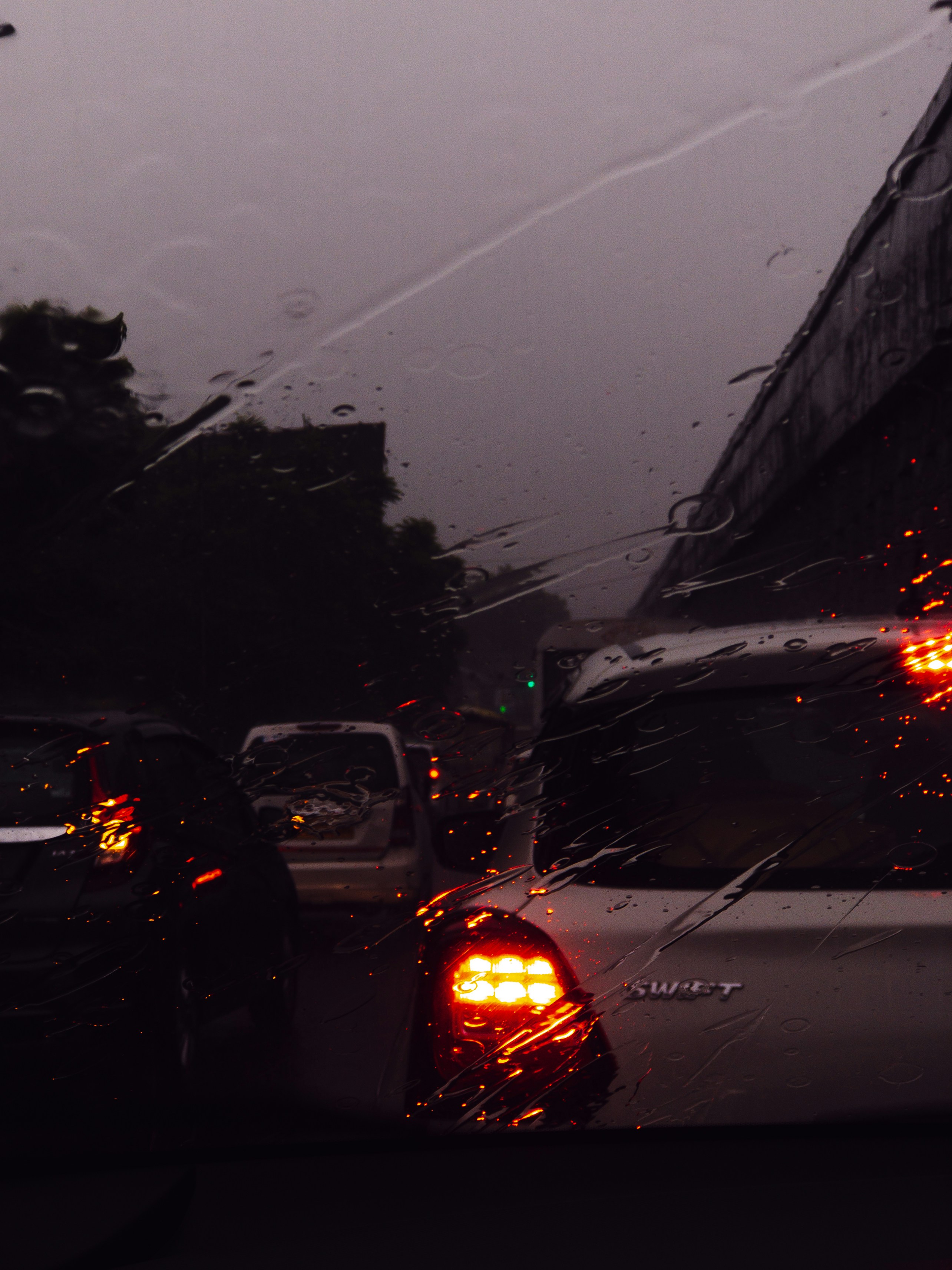 Red Taillight Mirage Through a Rain-Drenched Windshield