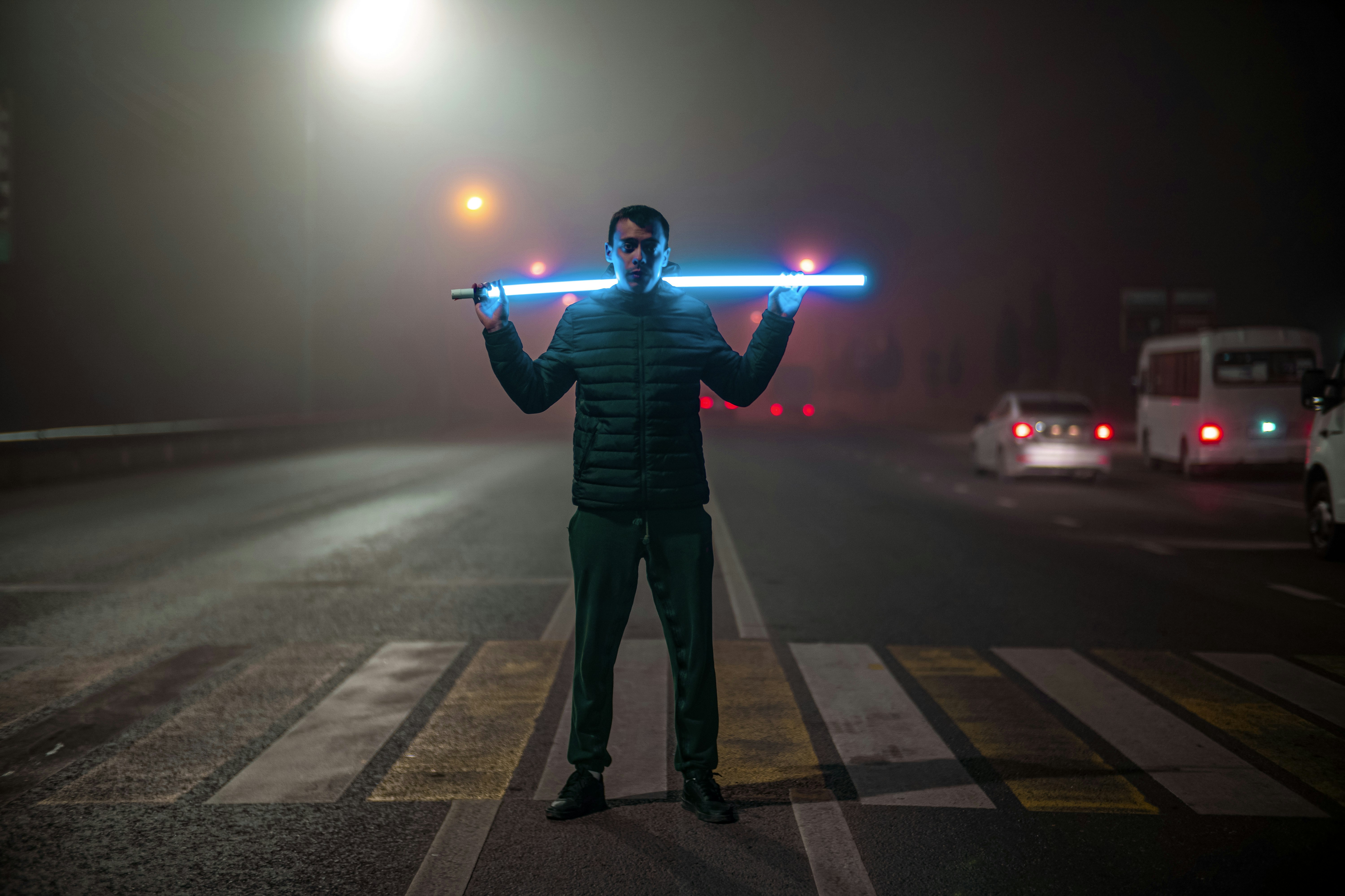 Neon Rods at Midnight: A Lone Figure on a Foggy Crosswalk