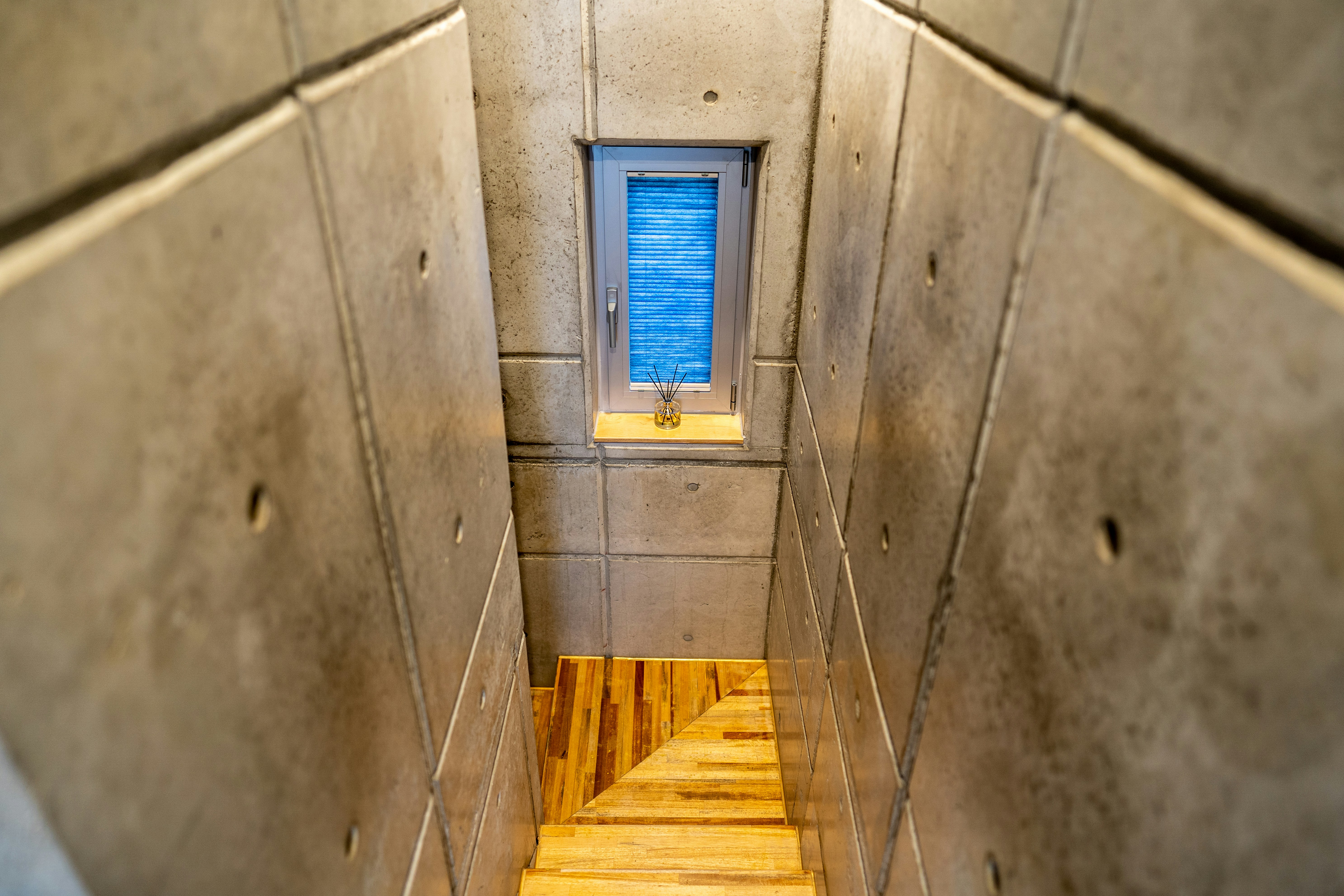 Blue Window Descent: Concrete Stairwell Framed by Light