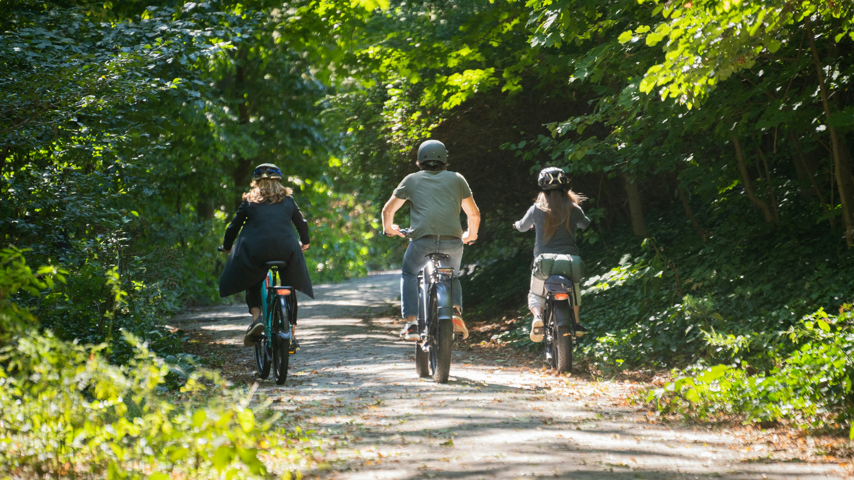 A group of people riding bikes on a dirt road photo – Free Ebikes Image ...