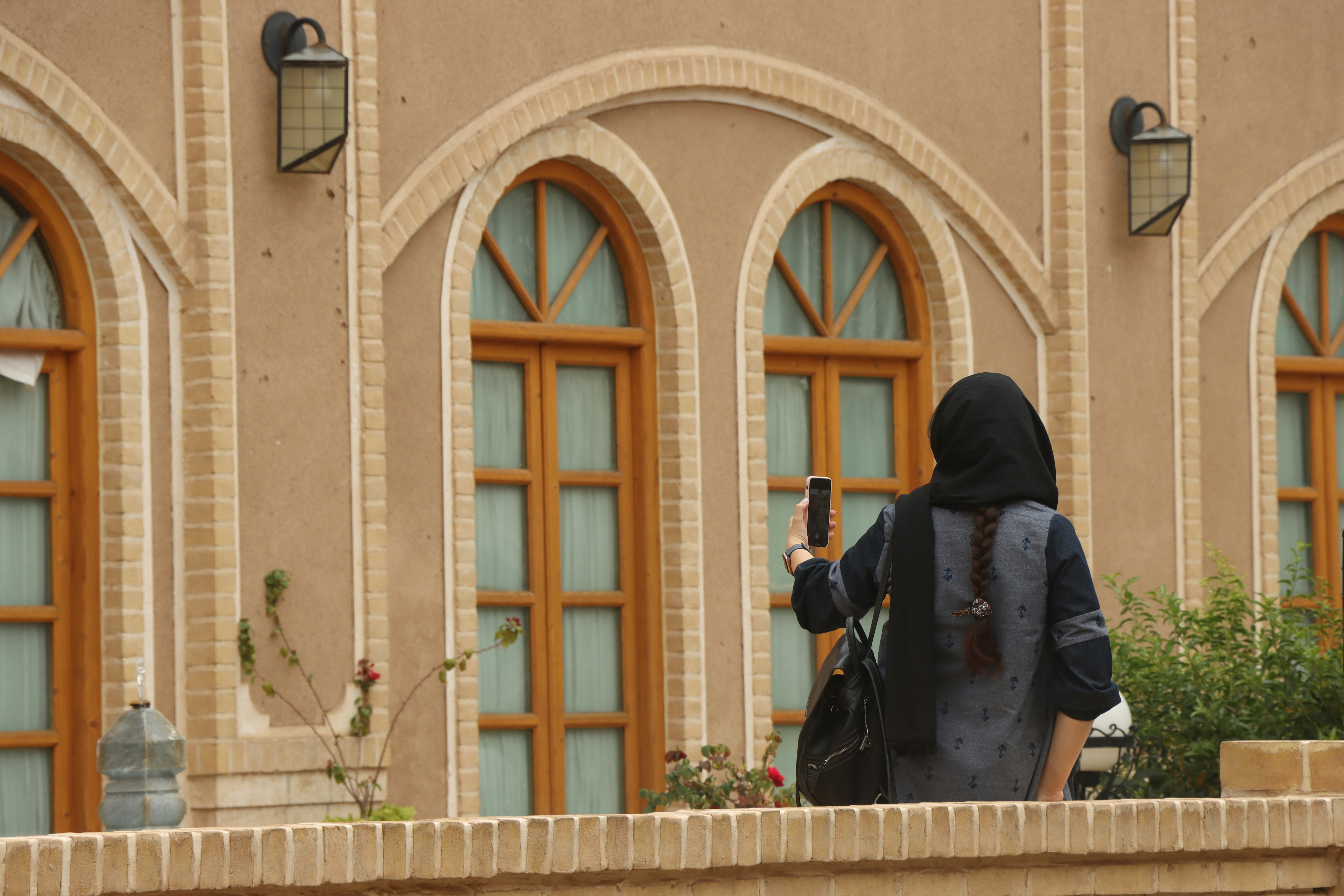 Silent Social Moment: A Woman in Hijab Captures a Cityscape