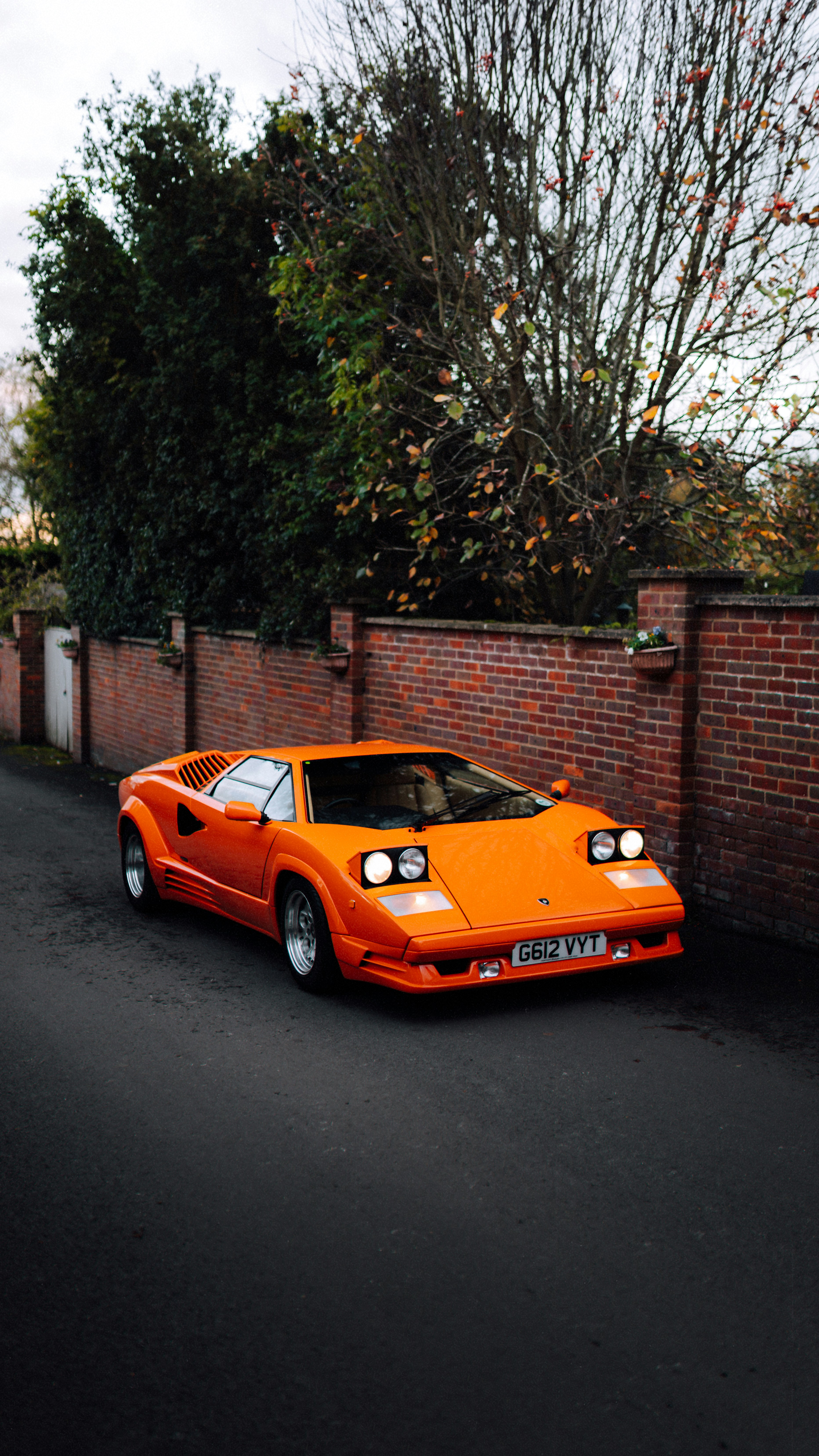 Foto zum Thema Ein orangefarbenes Auto, das auf einer Straße geparkt ...