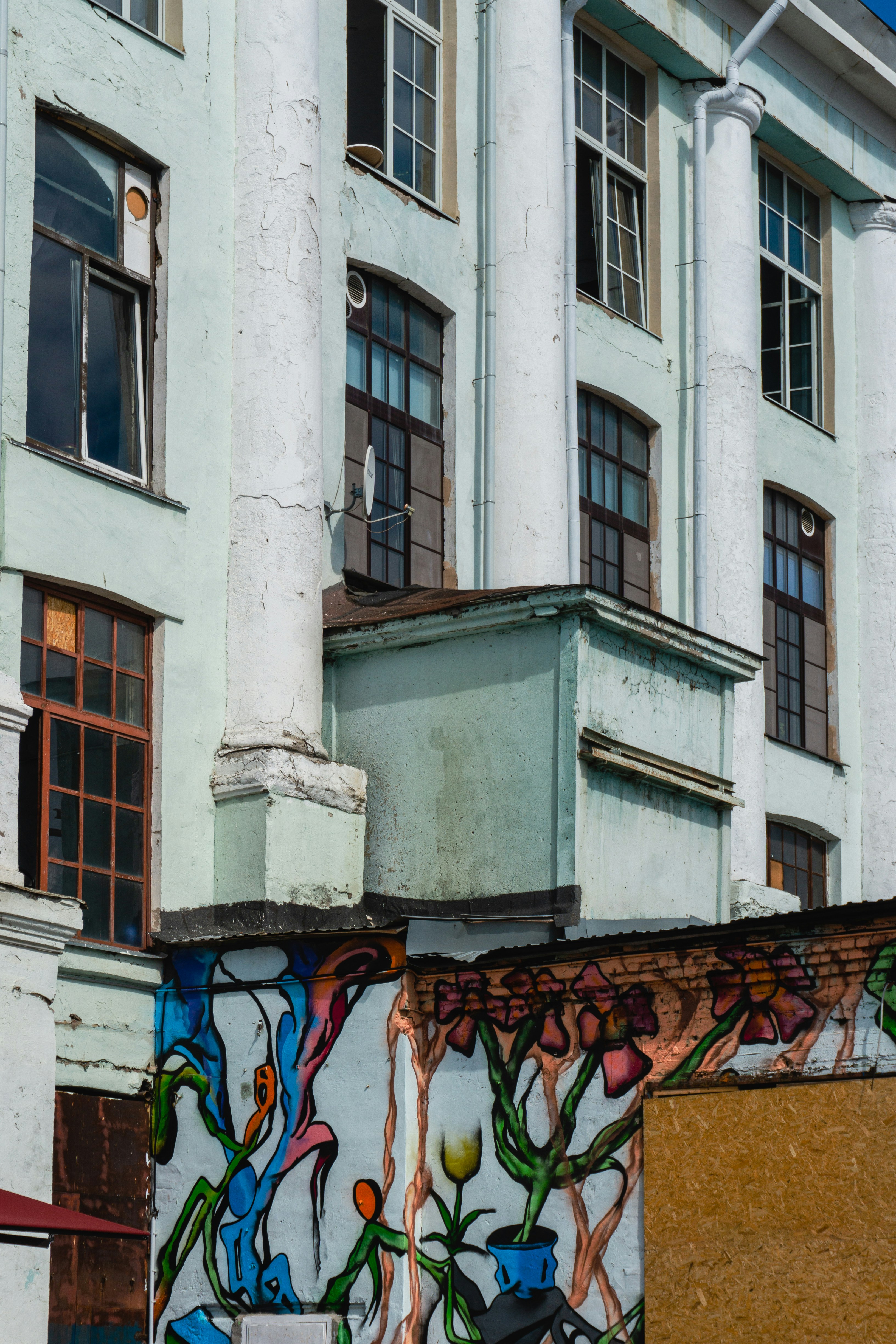 Pastel Columns Meet Wild Graffiti on a Weathered City Facade