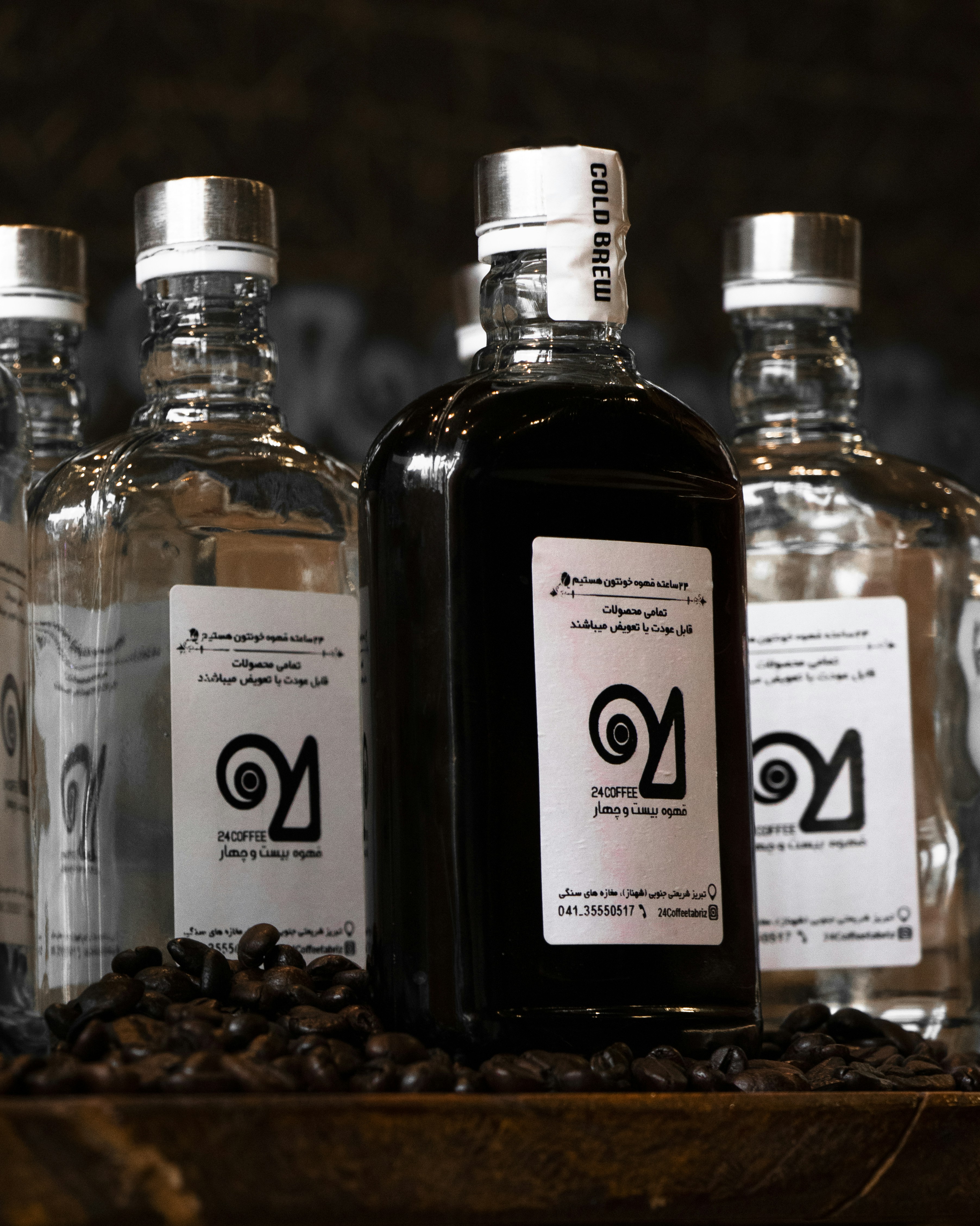 Central Bottle of Dark Syrup Emerges from a Row of Clear Bottles