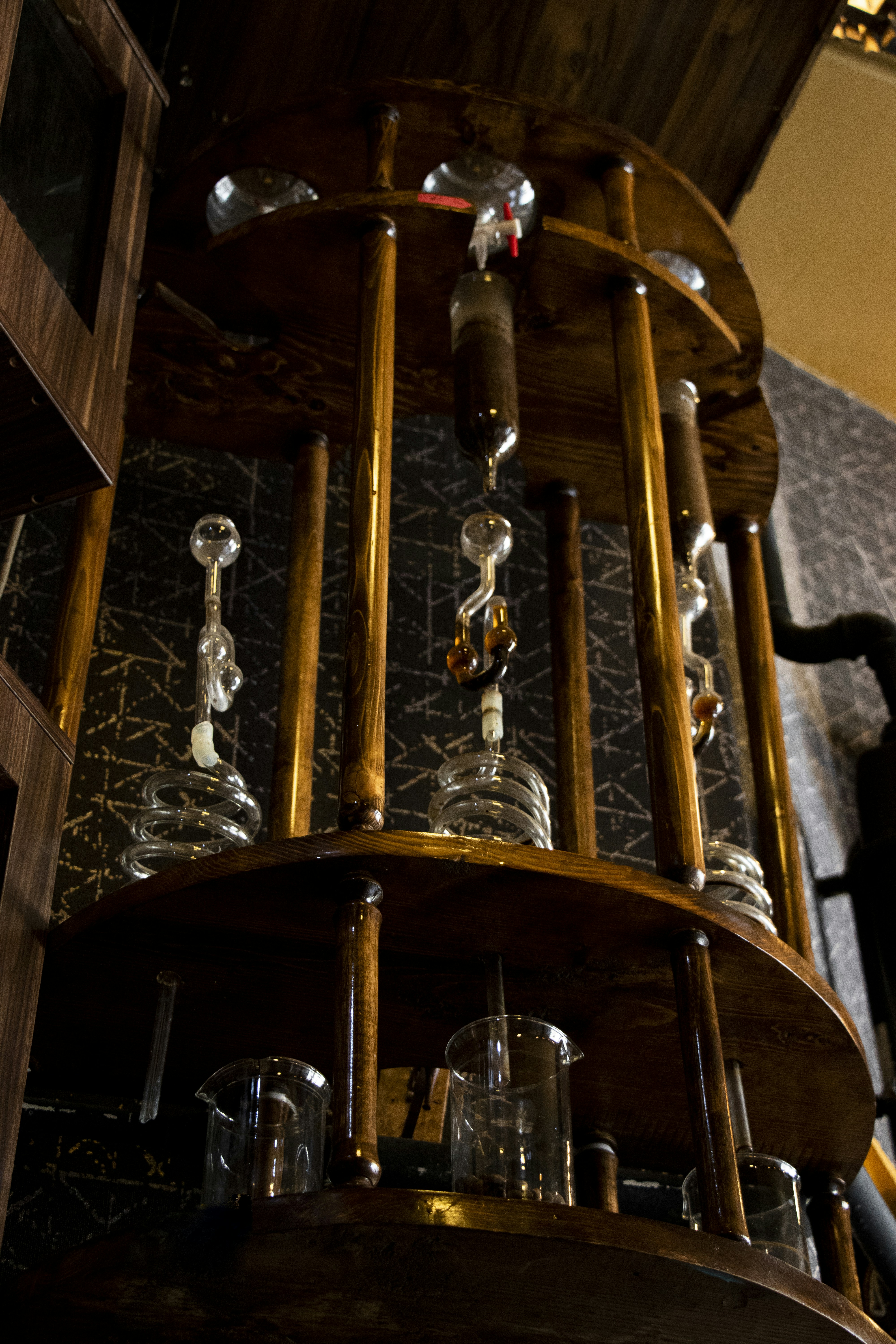 Glass on a Wooden Carousel: A Vintage Display in Dim Light