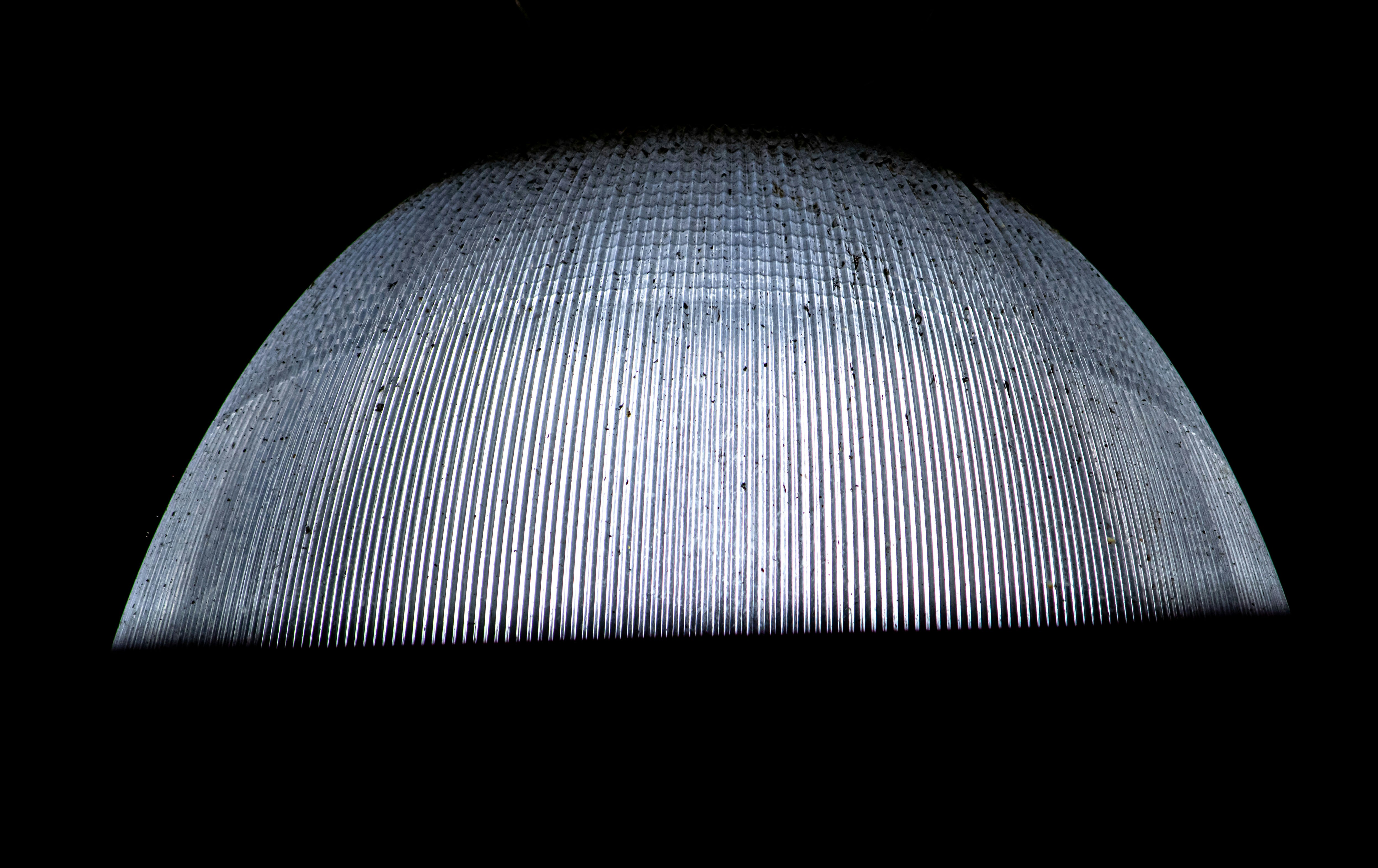 Translucent dome structure illuminated from below, showcasing intricate line patterns against a dark background.
