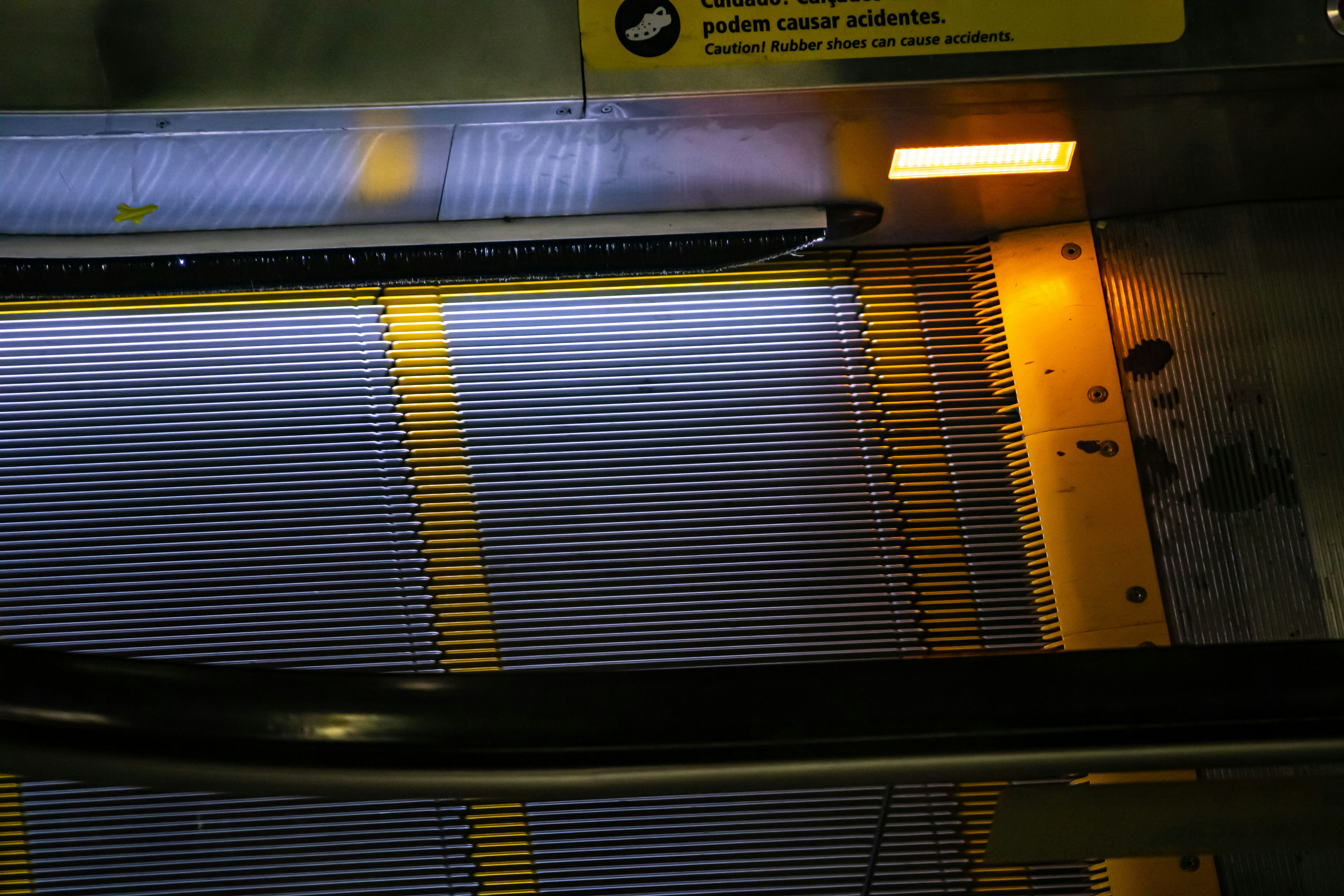 Ribbed Neon in Motion: Close-Up of Escalator Steps