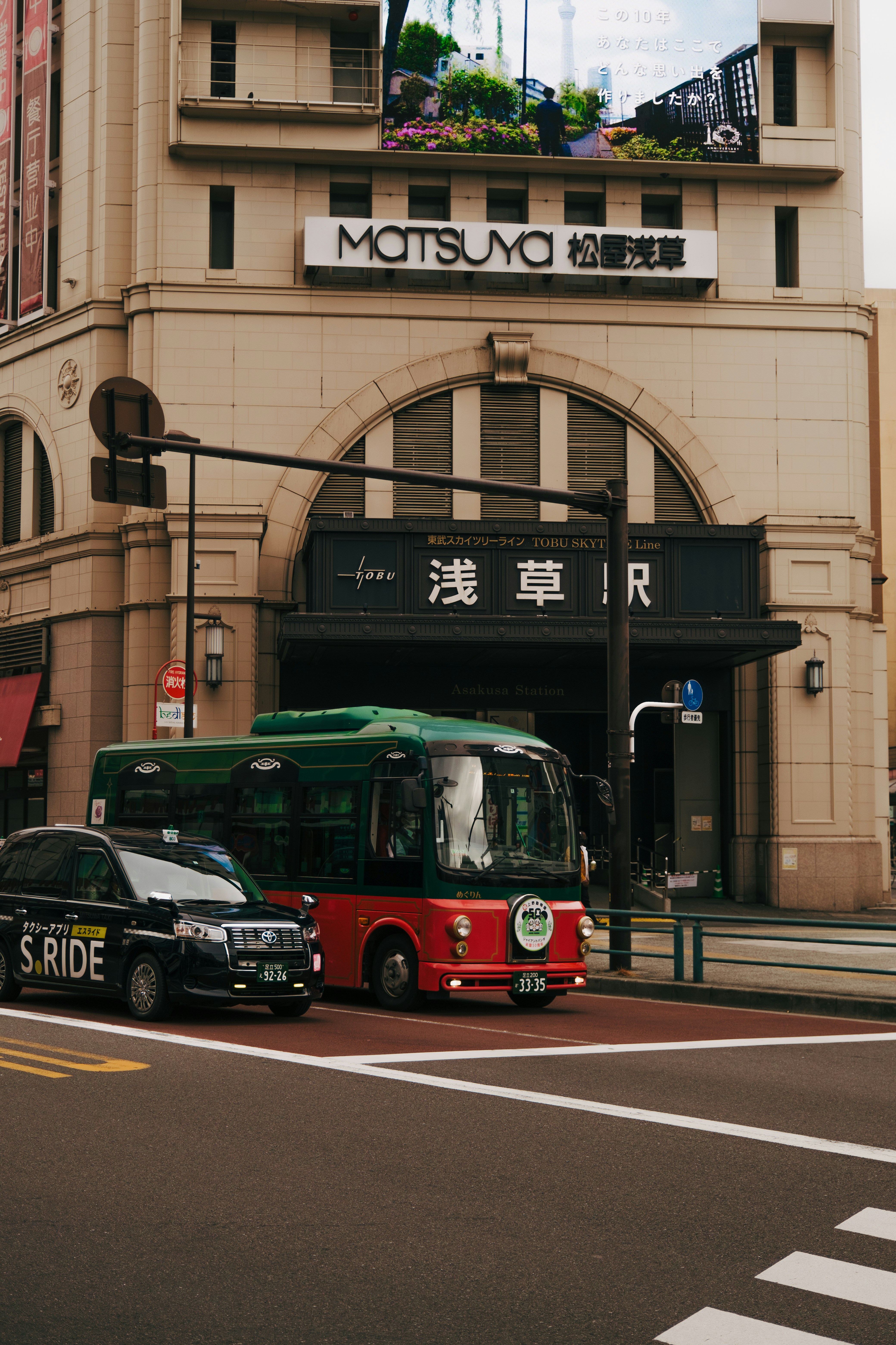 a bus and a car driving under a sign