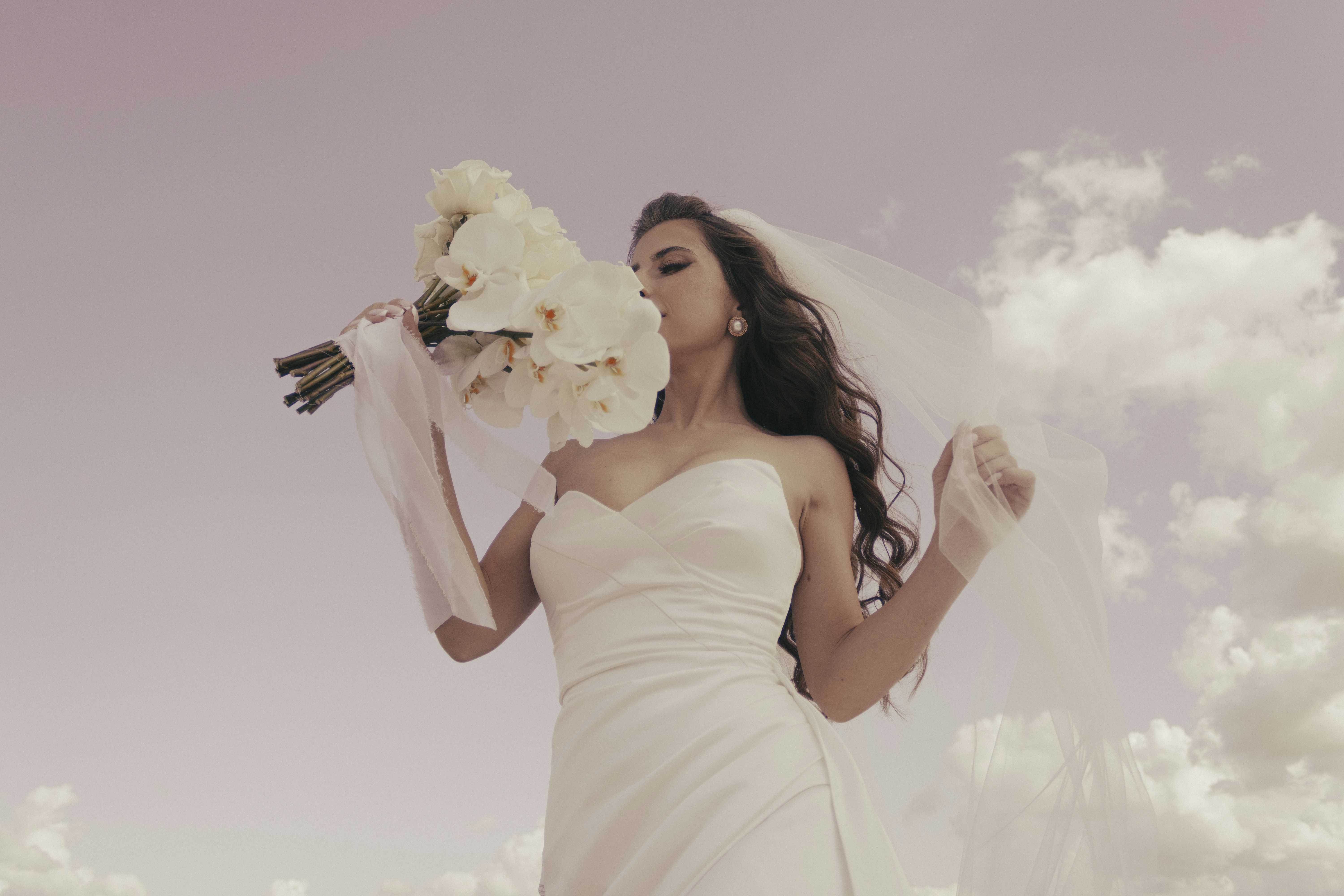 Bouquet in the Breeze: Bride Against a Pink-tinged Sky