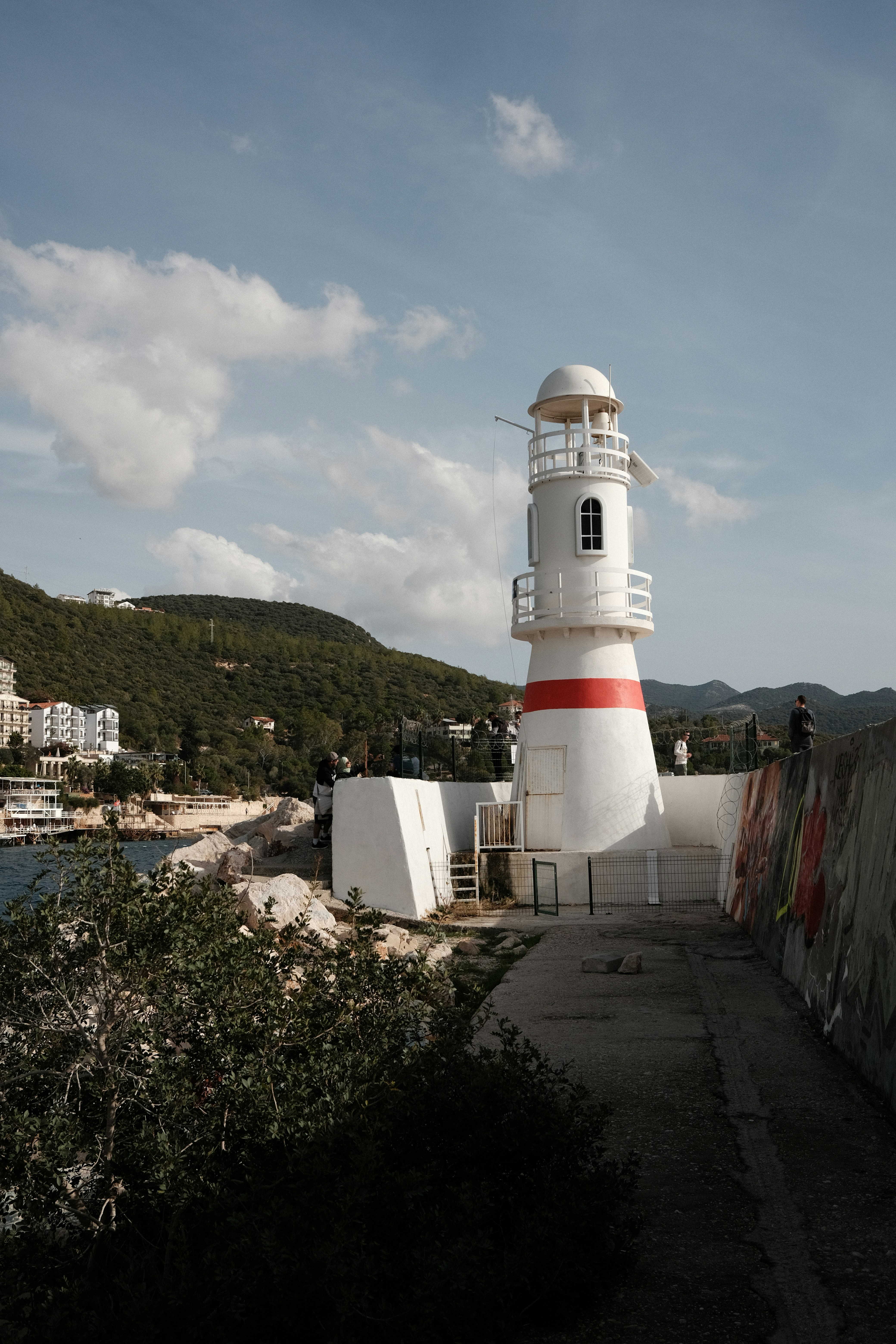 a white lighthouse on a hill with Coquille River Light in the background