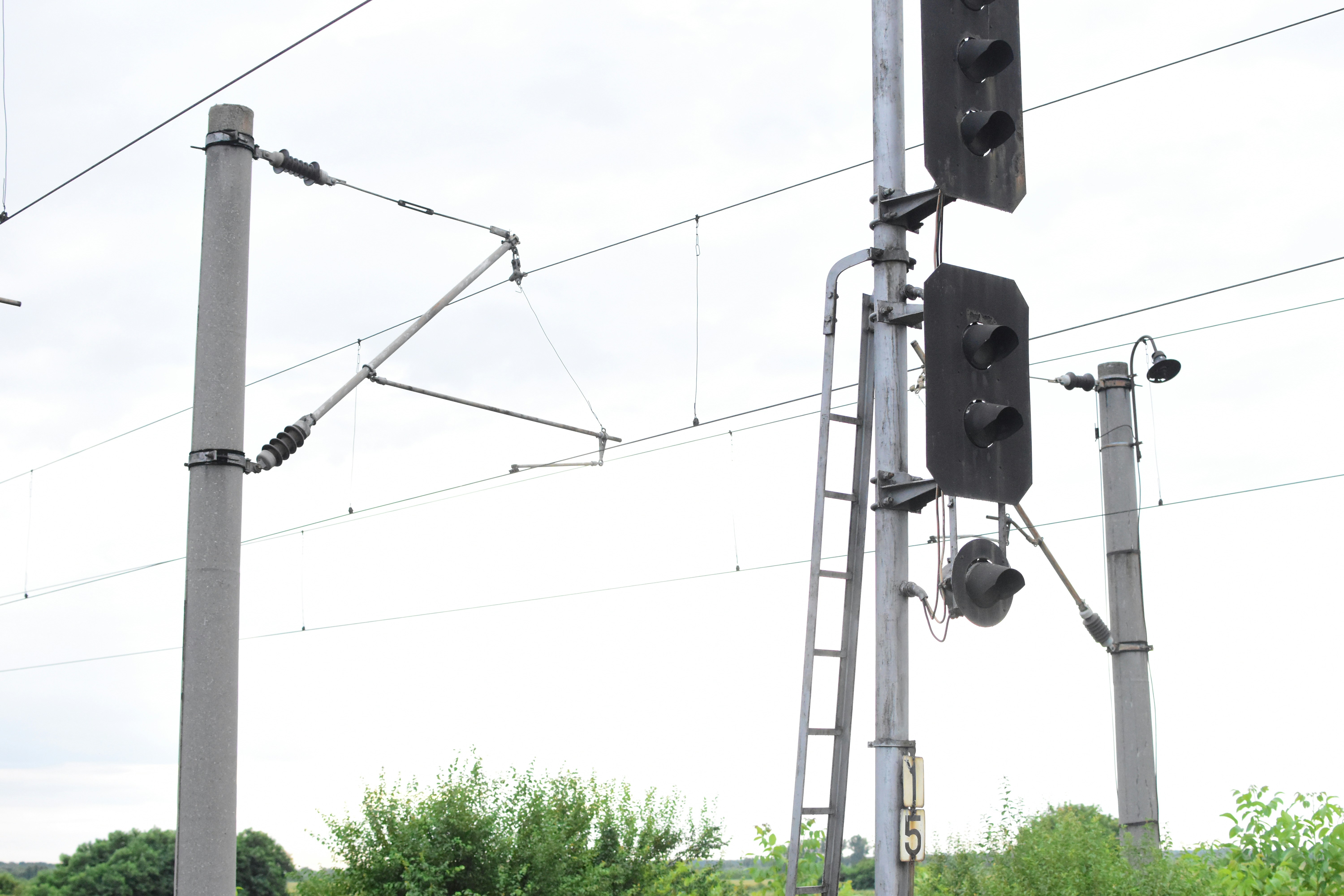 Railside Signals: Ladders, Wires, and Steel Sentinels in Overcast Light