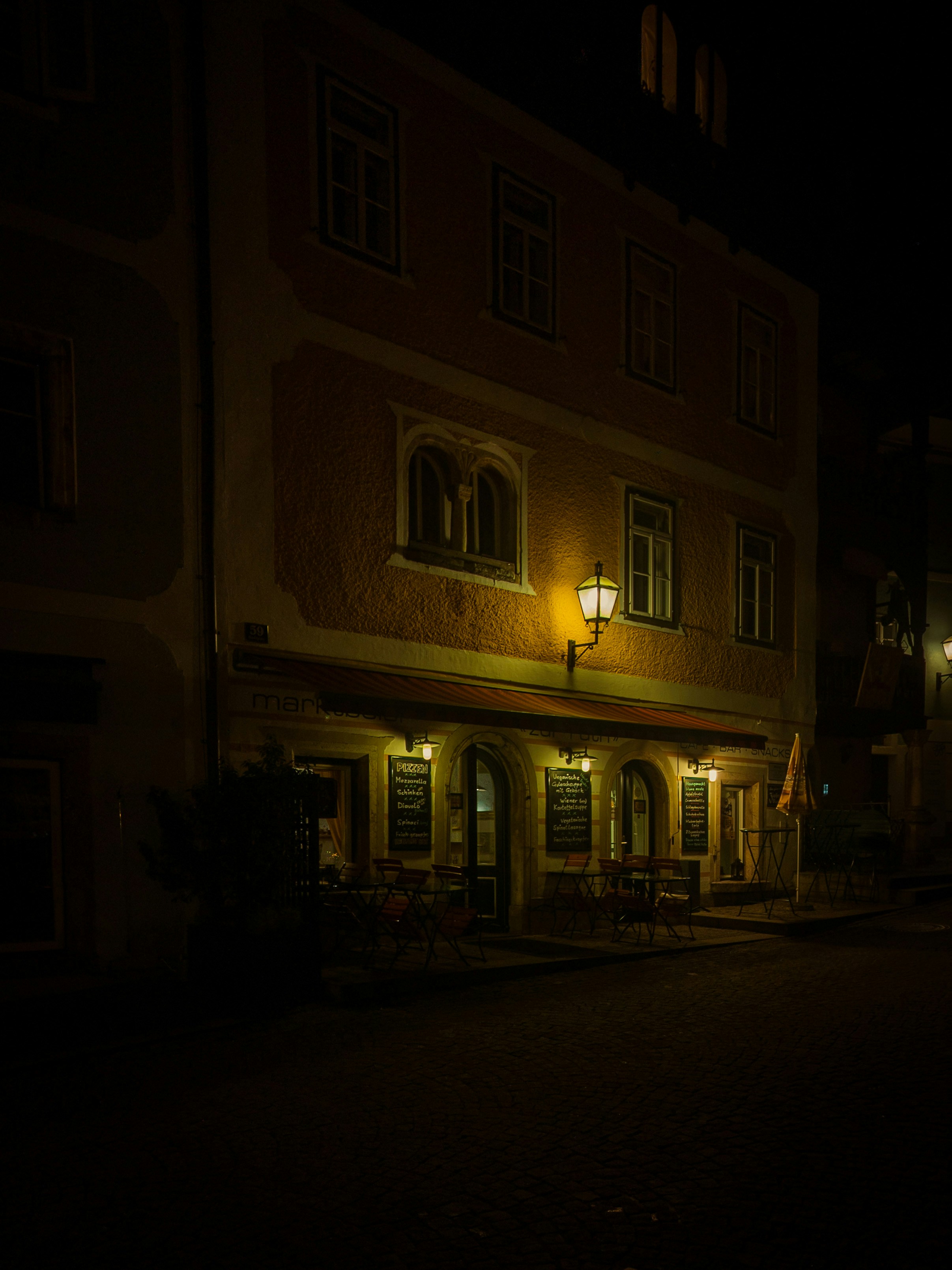 Warm Streetfront Entropy: A Quiet Café Under Amber Streetlamps