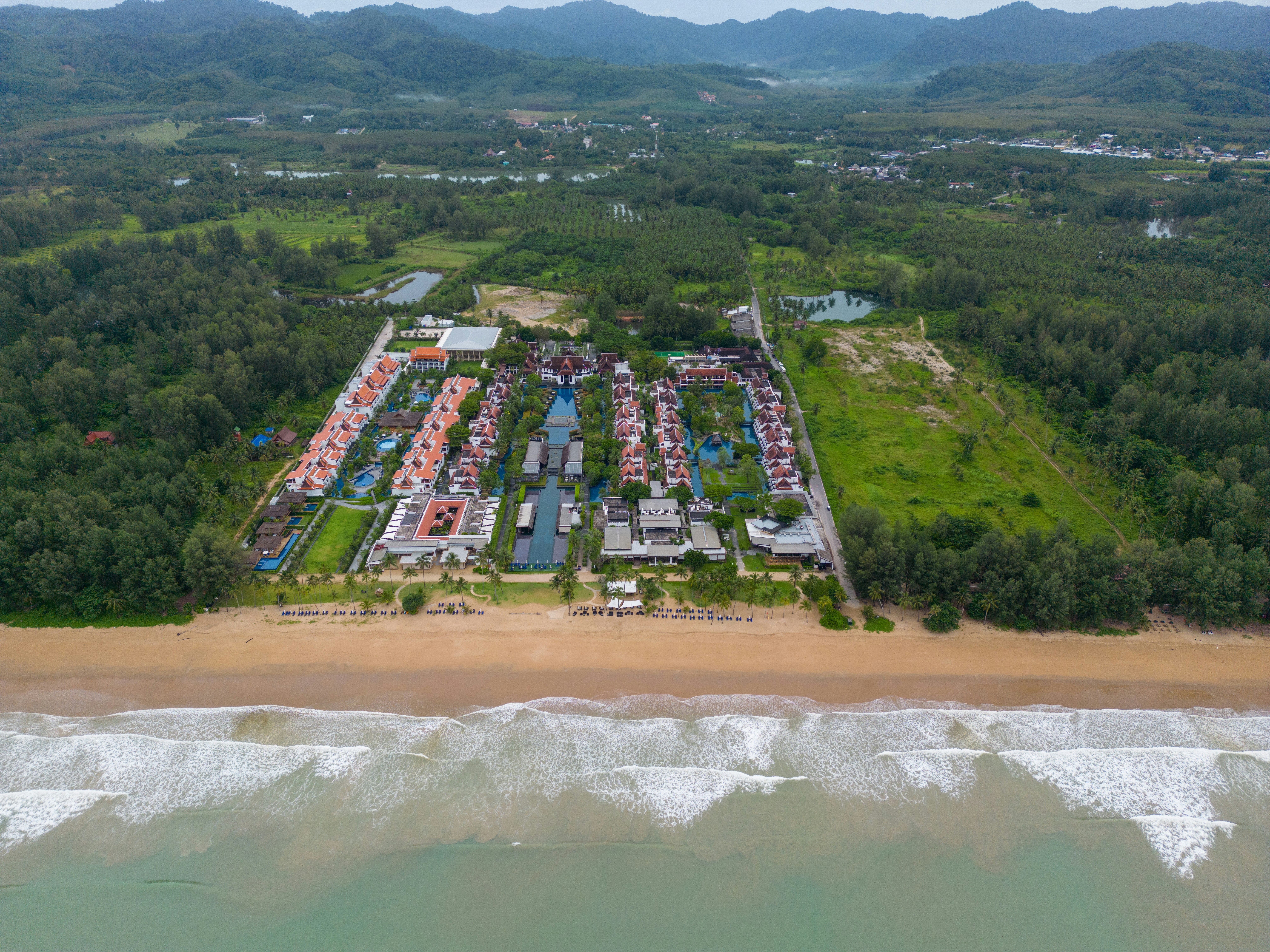 Shoreline Retreat: Aerial Portrait of a Beachfront Resort Nestled in Coastal Green