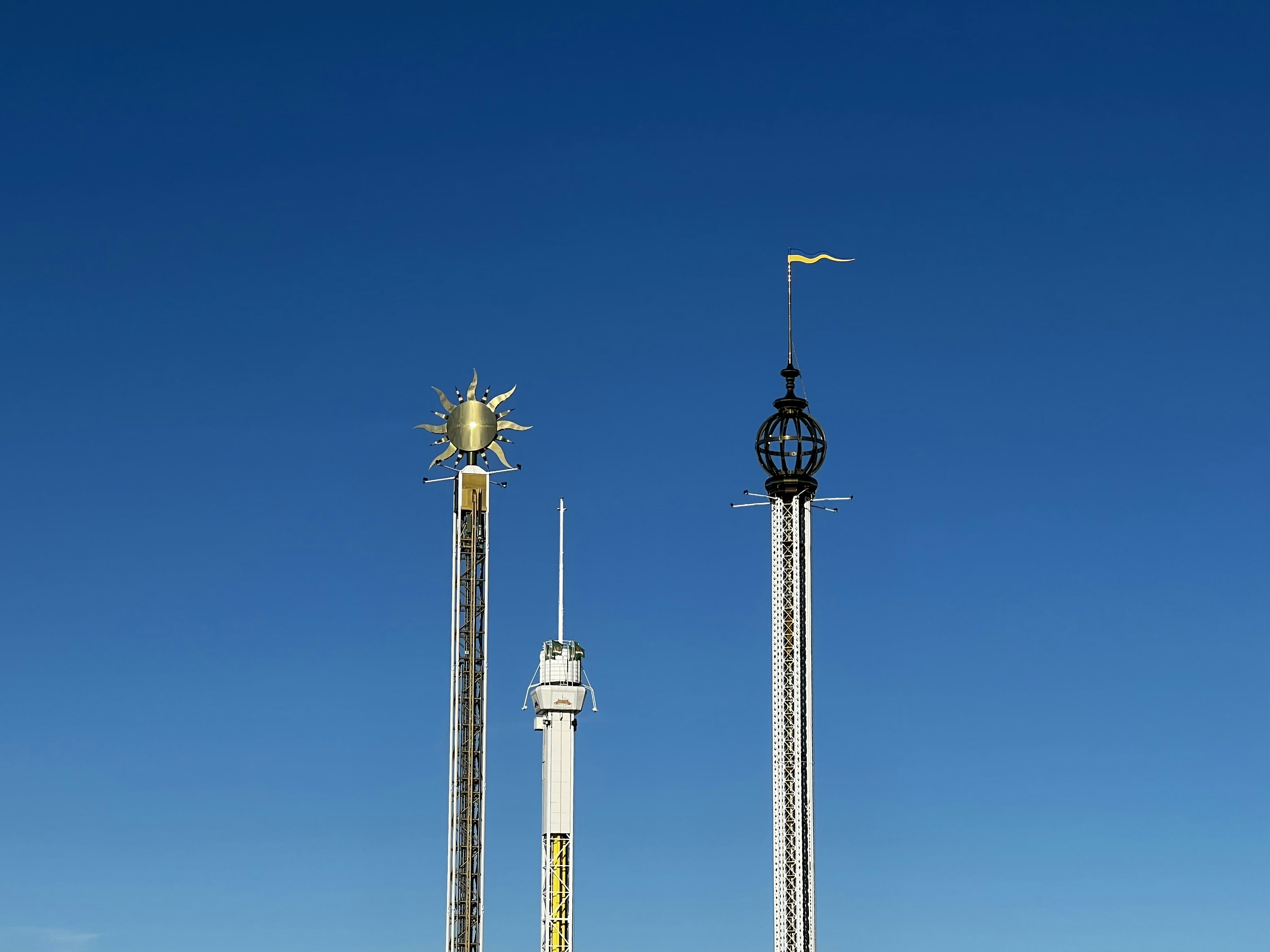 A couple of tall towers with a gold and silver ball on top photo – Free ...