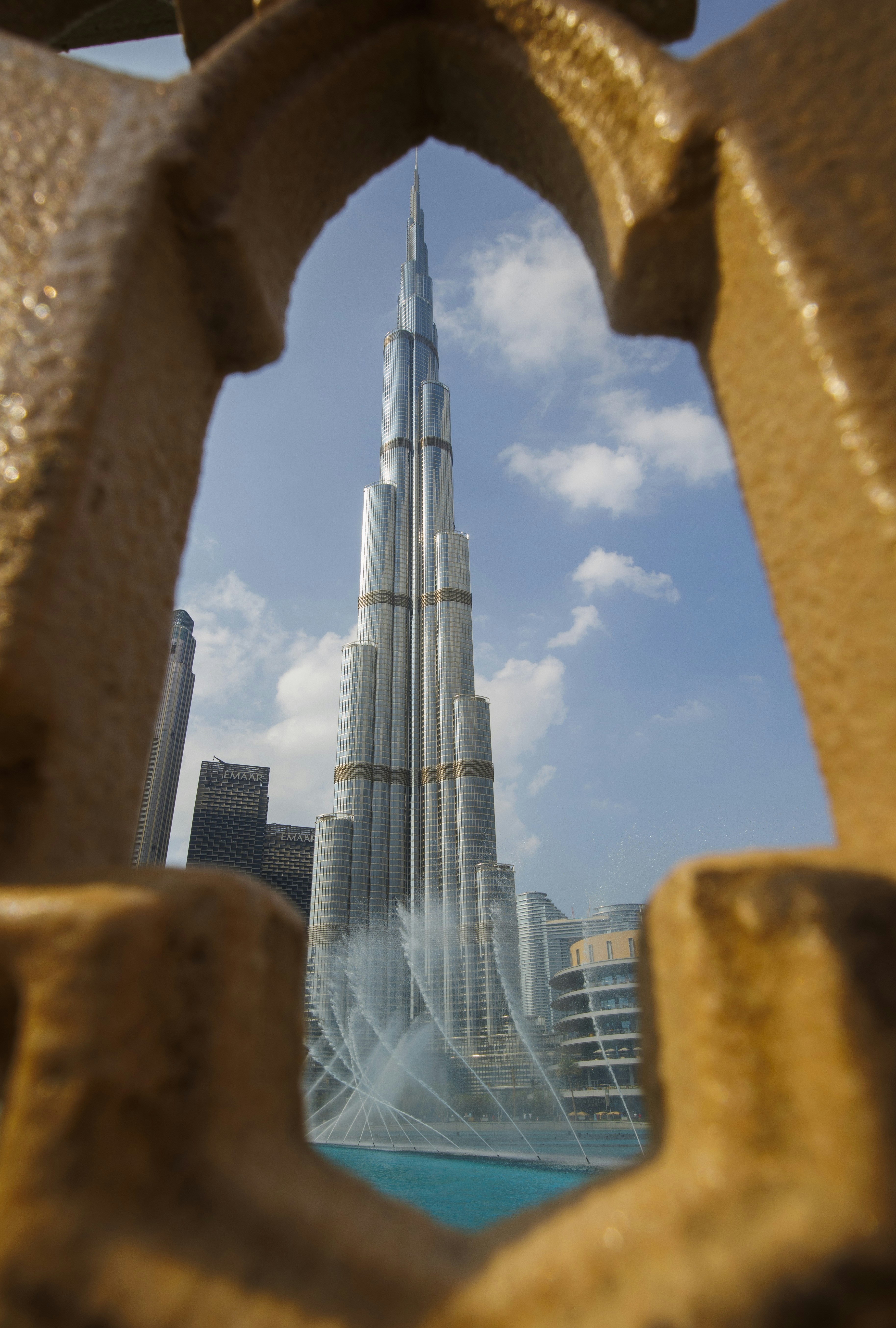 Rusted Frame, Towering Skyline: Burj Khalifa Through a Weathered Arch