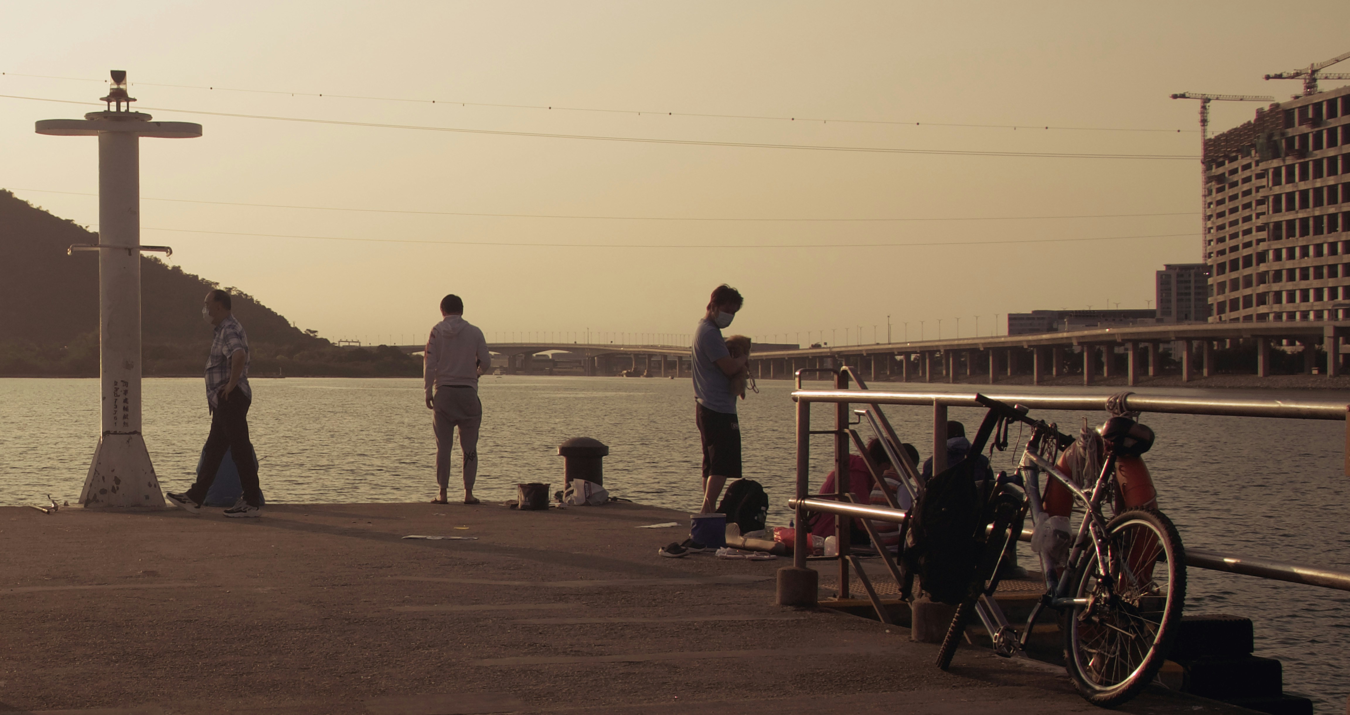 Dusk at the Pier: Figures and Wheels in Quiet Harbor Light