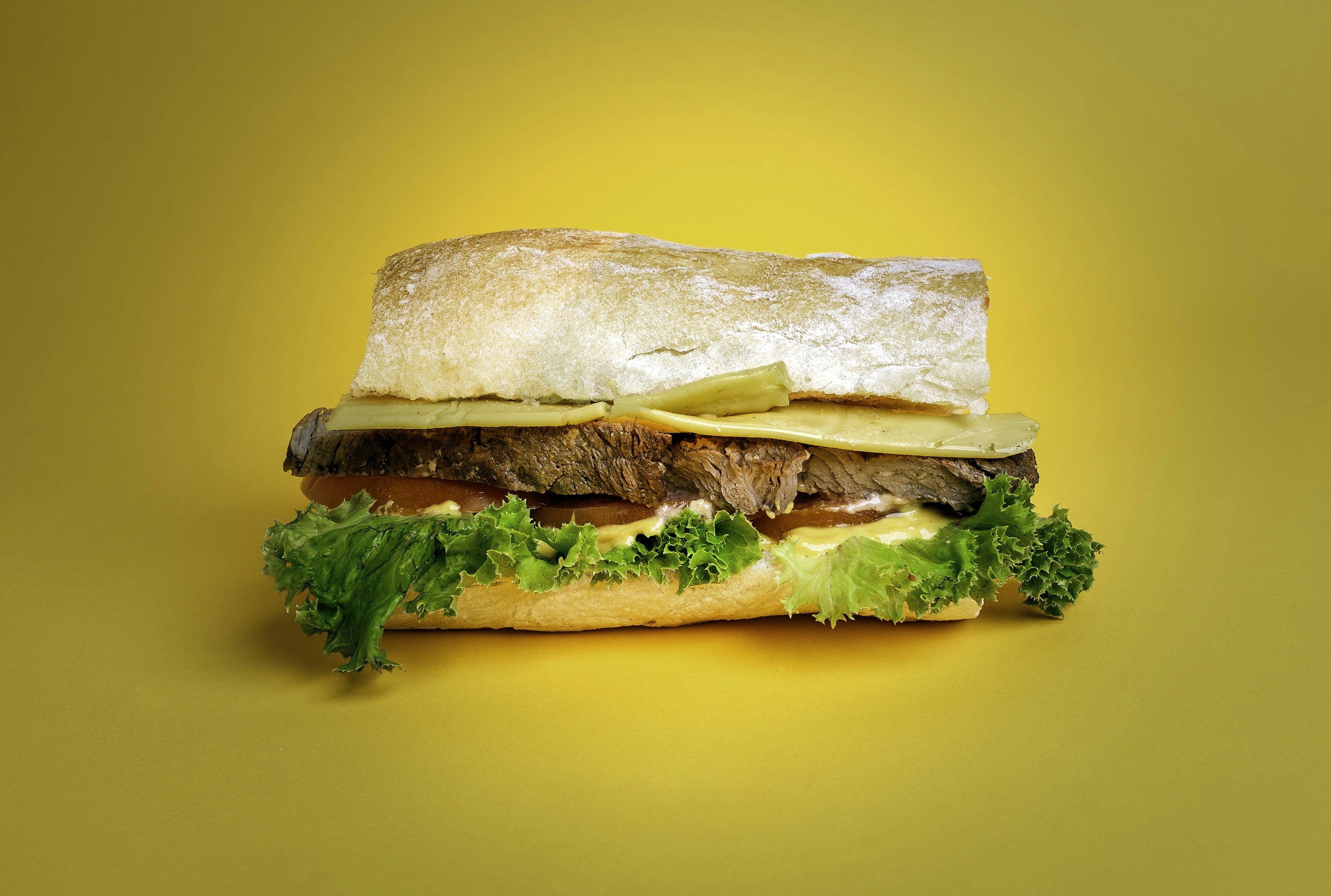 A sandwich with lettuce and meat on a wooden surface photo – Free Food ...