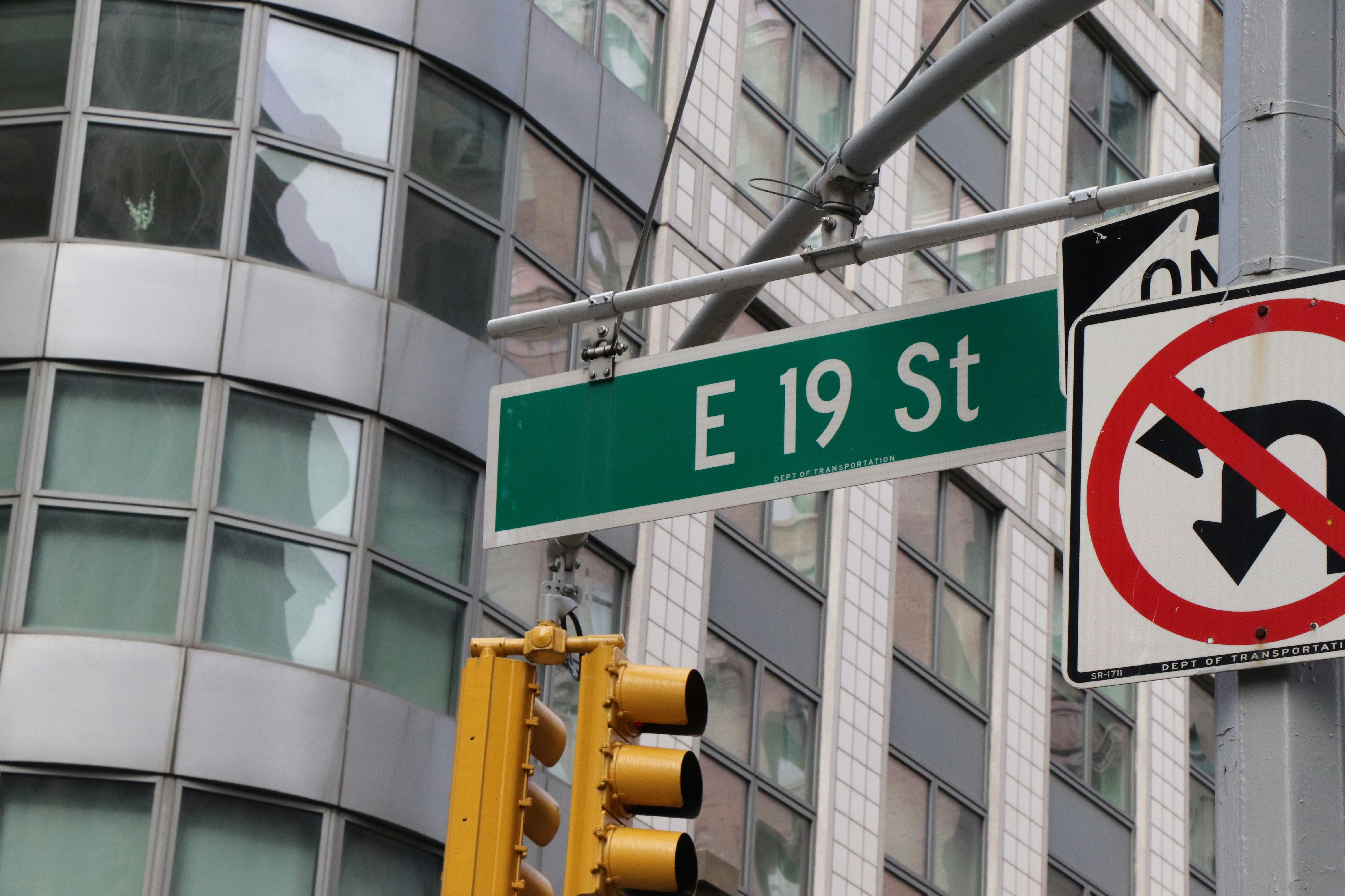 A street sign next to a traffic light photo – Free New york Image on ...
