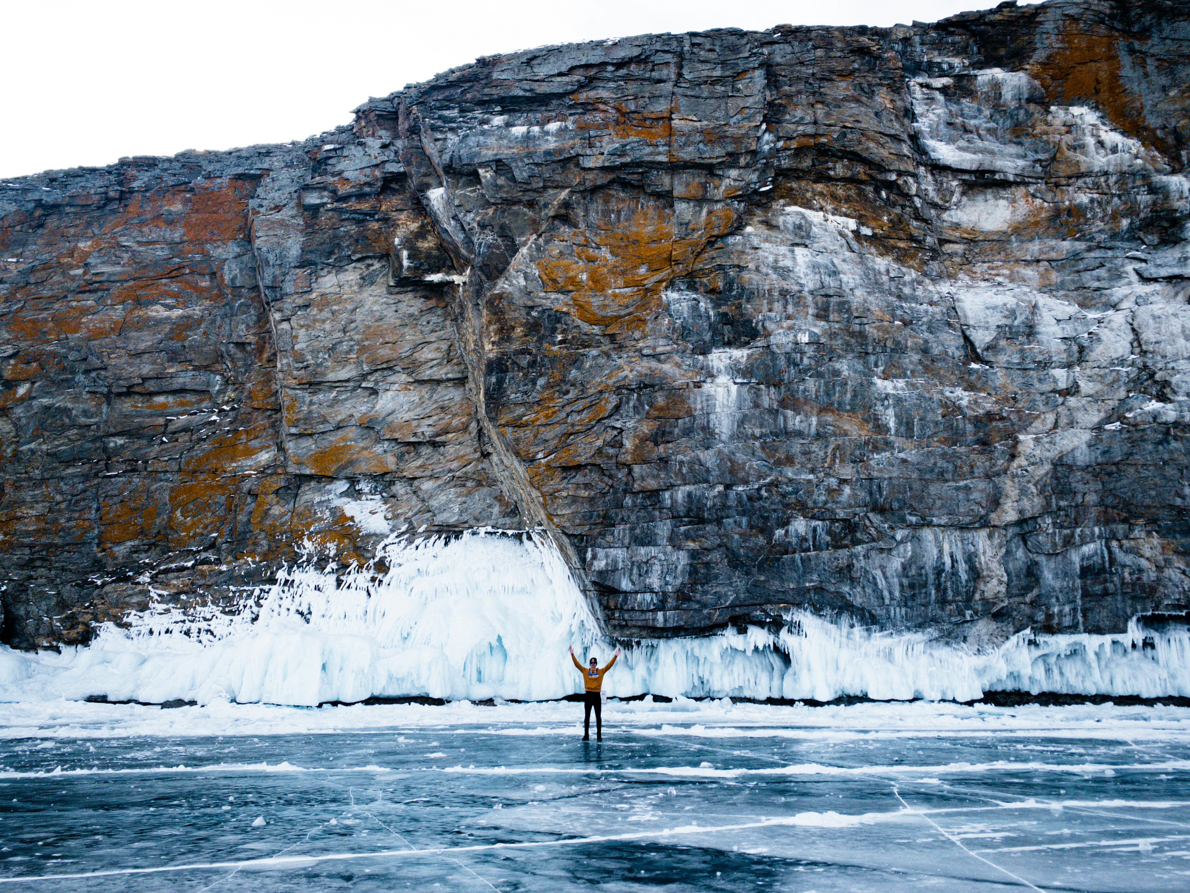 Silhouette at the Ice Edge: A Figure Between Sea and Cliff