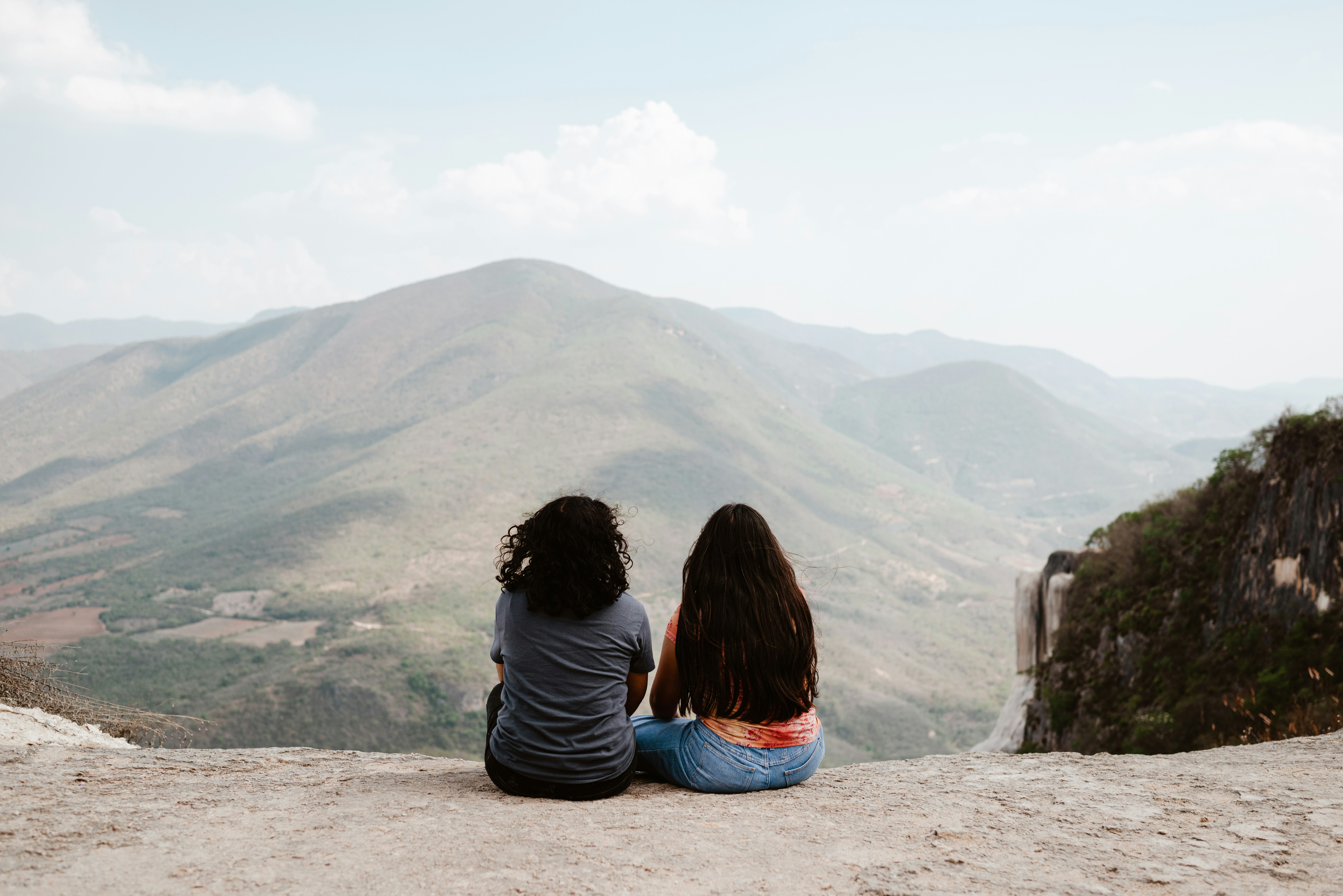 Two people sitting on a rock overlooking a valley photo – Free Culture ...