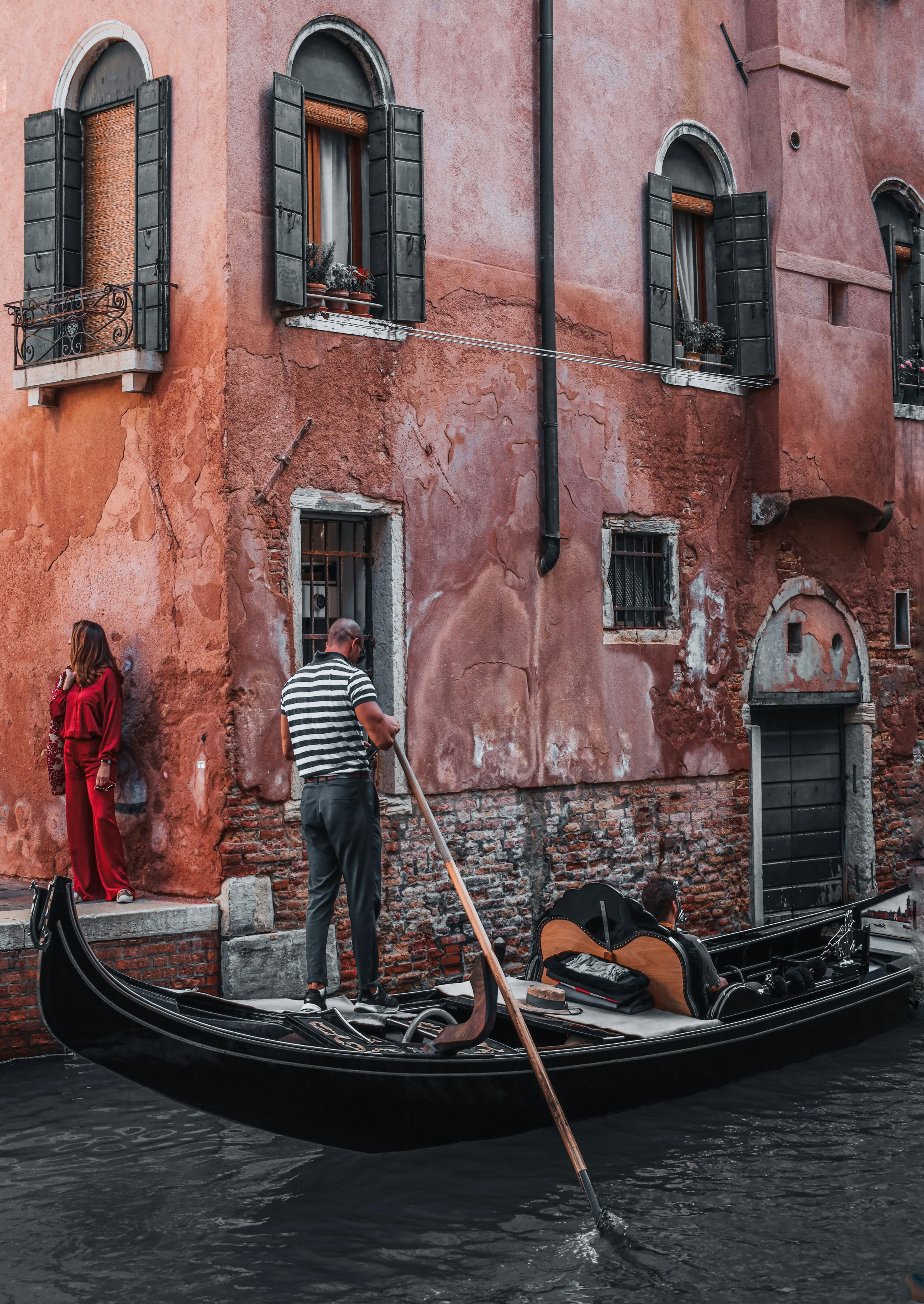 Striped Sailor and Scarlet Figure by a Crumbling Pink Venetian Facade