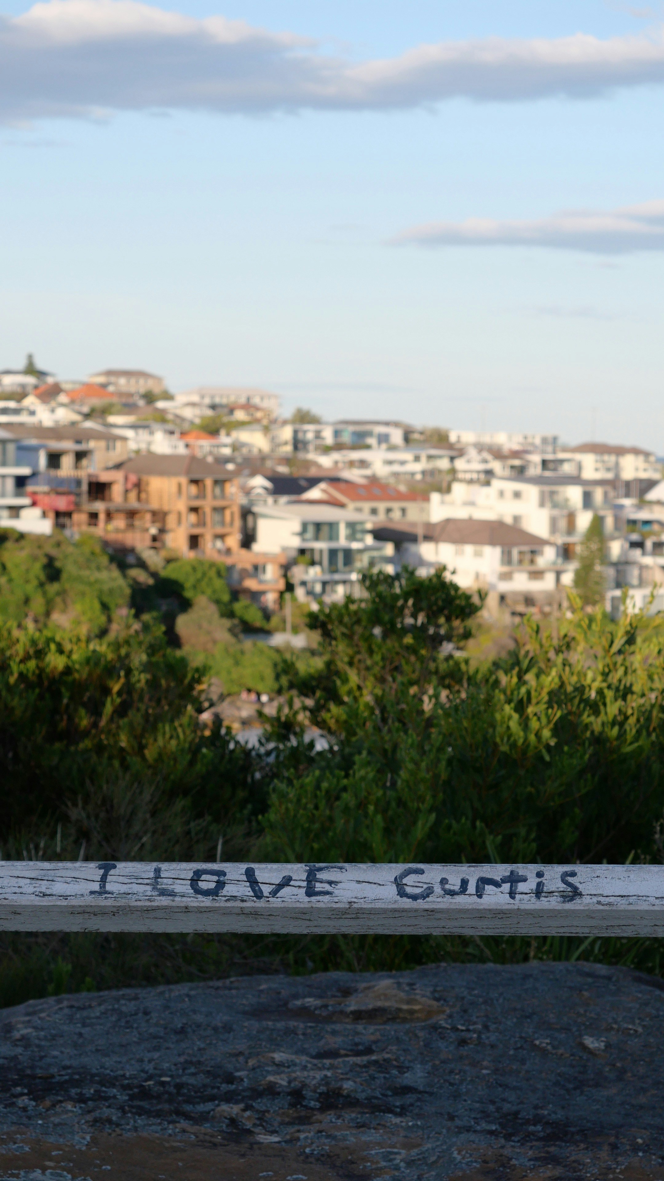 Love on the Rail: A Quiet Overlook Framing a Sunlit Hillside Town